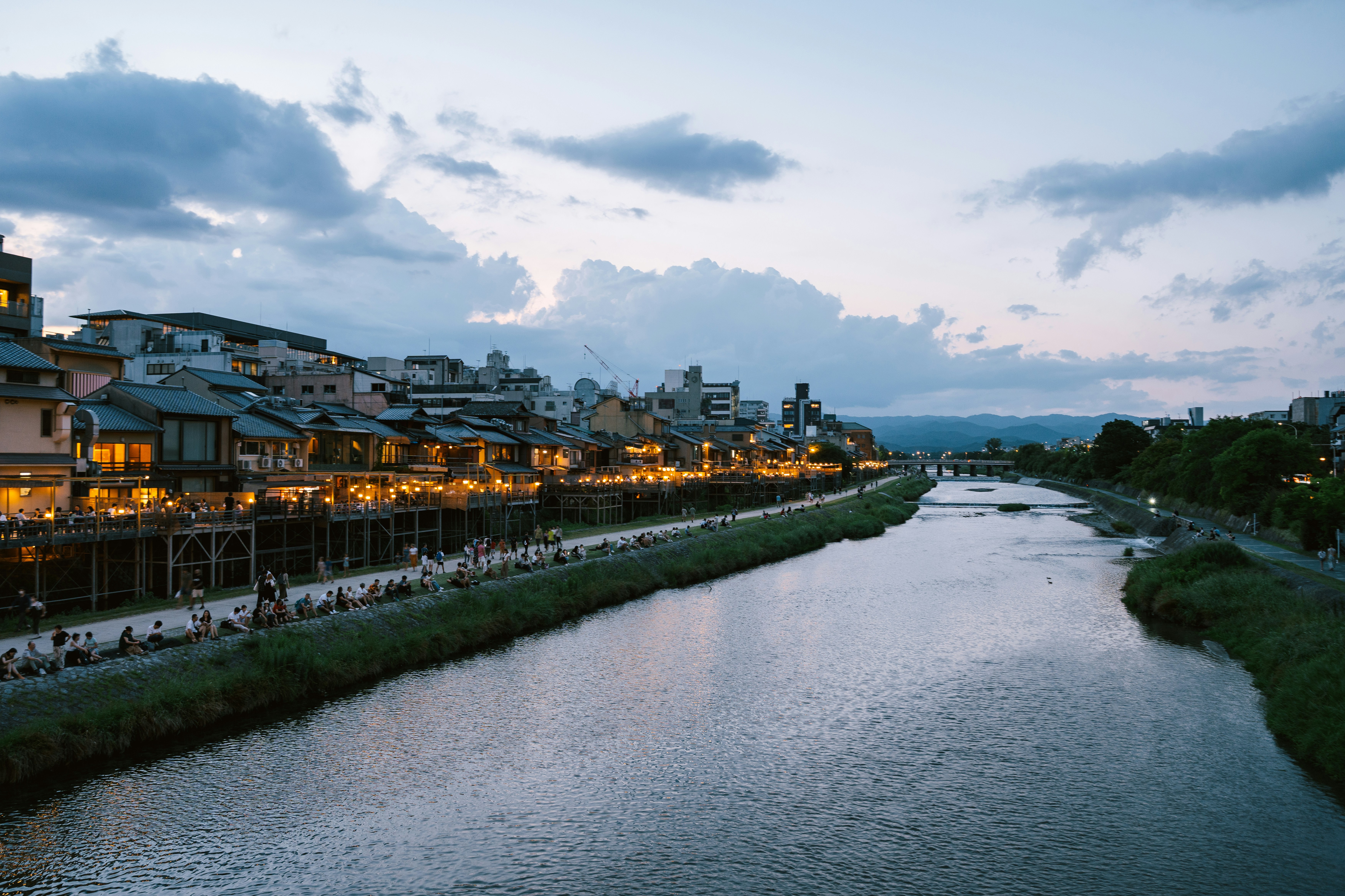 Evening Riverwalk: Warm Lights Along a Shōtō Bridgefront