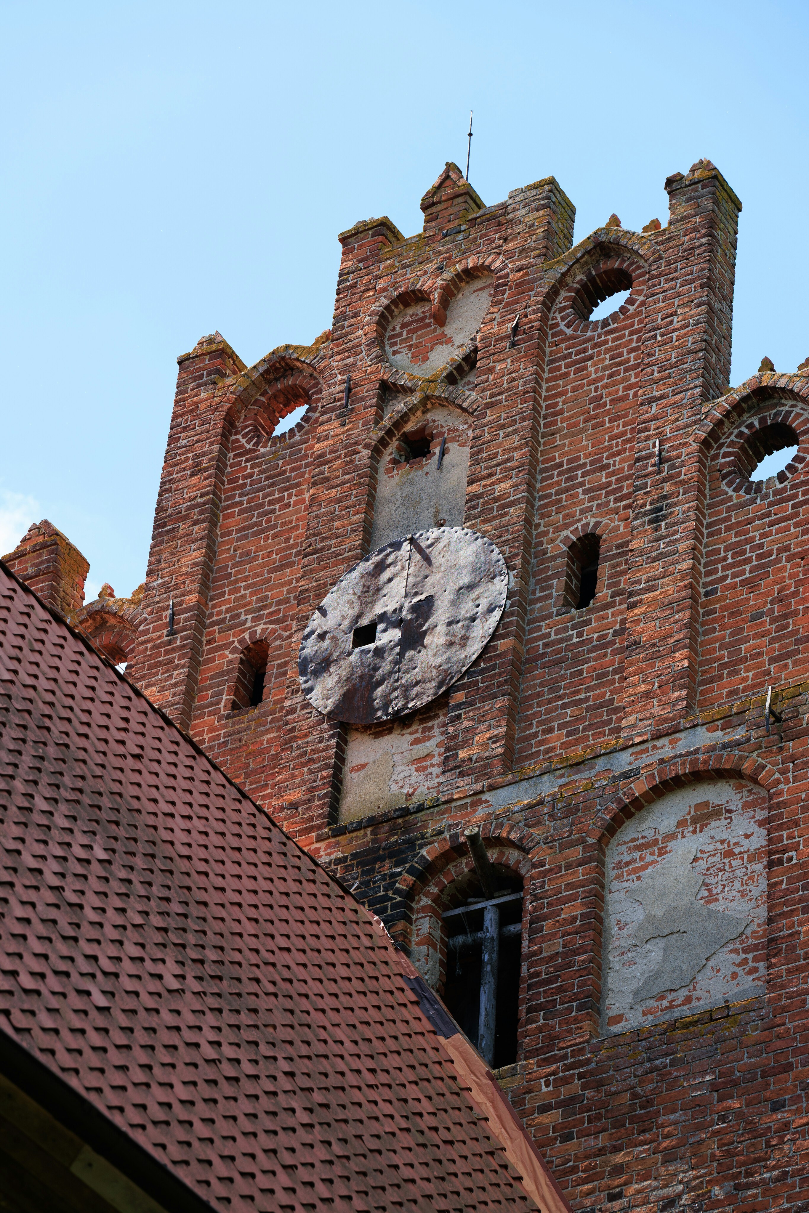 Brickwork Cathedral: A Weathered Clock Tower Under a Clear Blue Sky