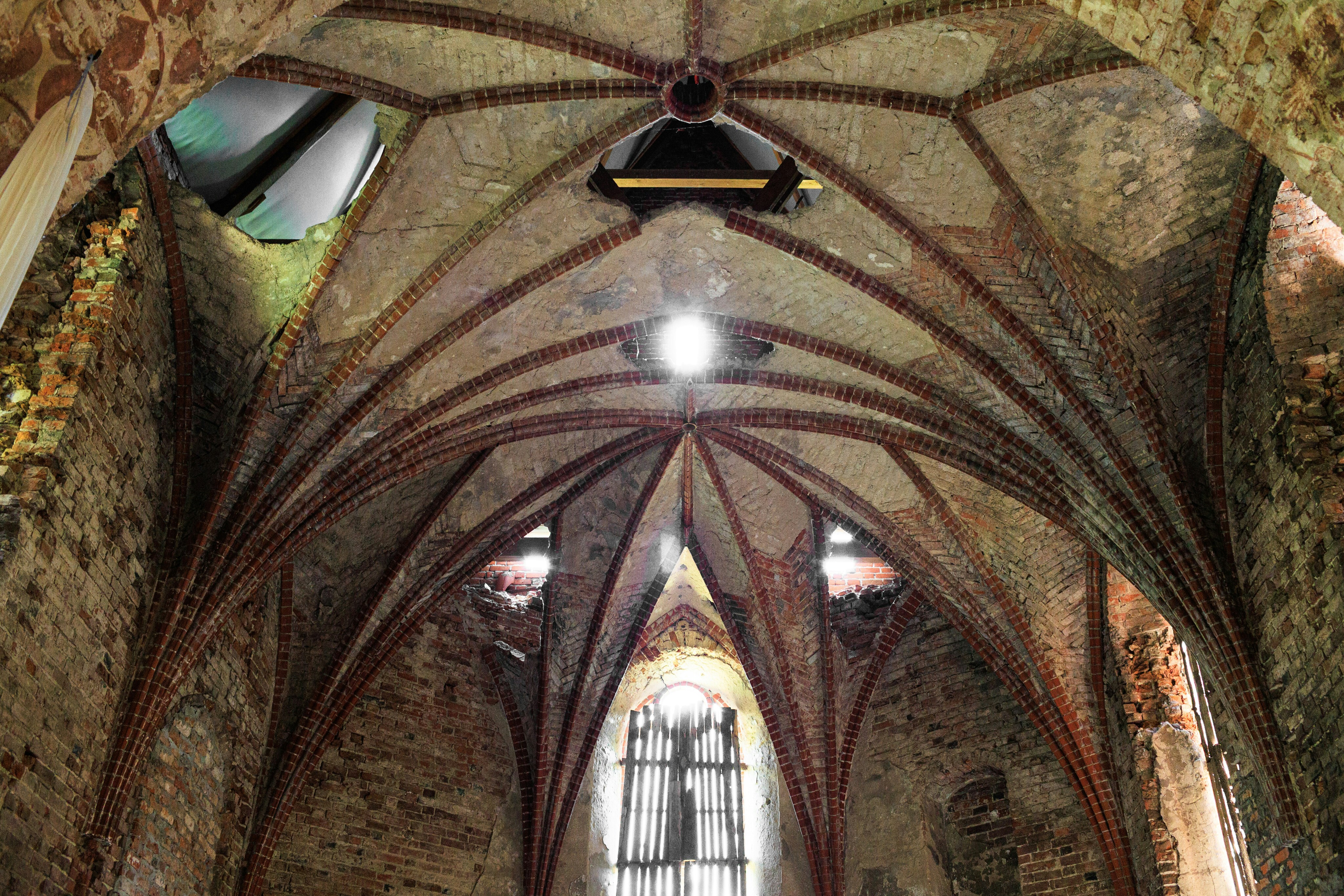 Intricate Gothic ribbed vaulting of a medieval brick church ceiling.