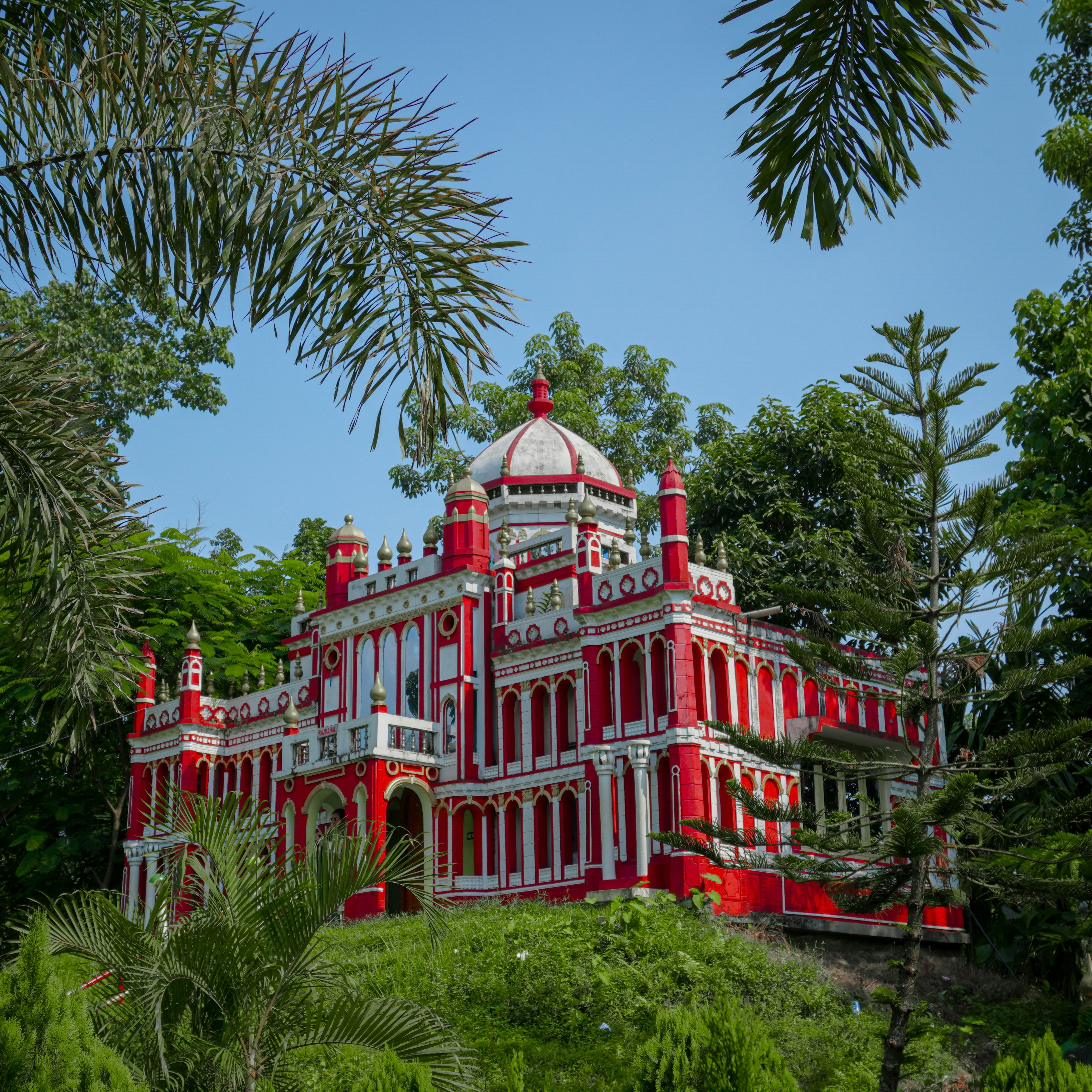 Red and White Hyphen Palace Rising from Greenery