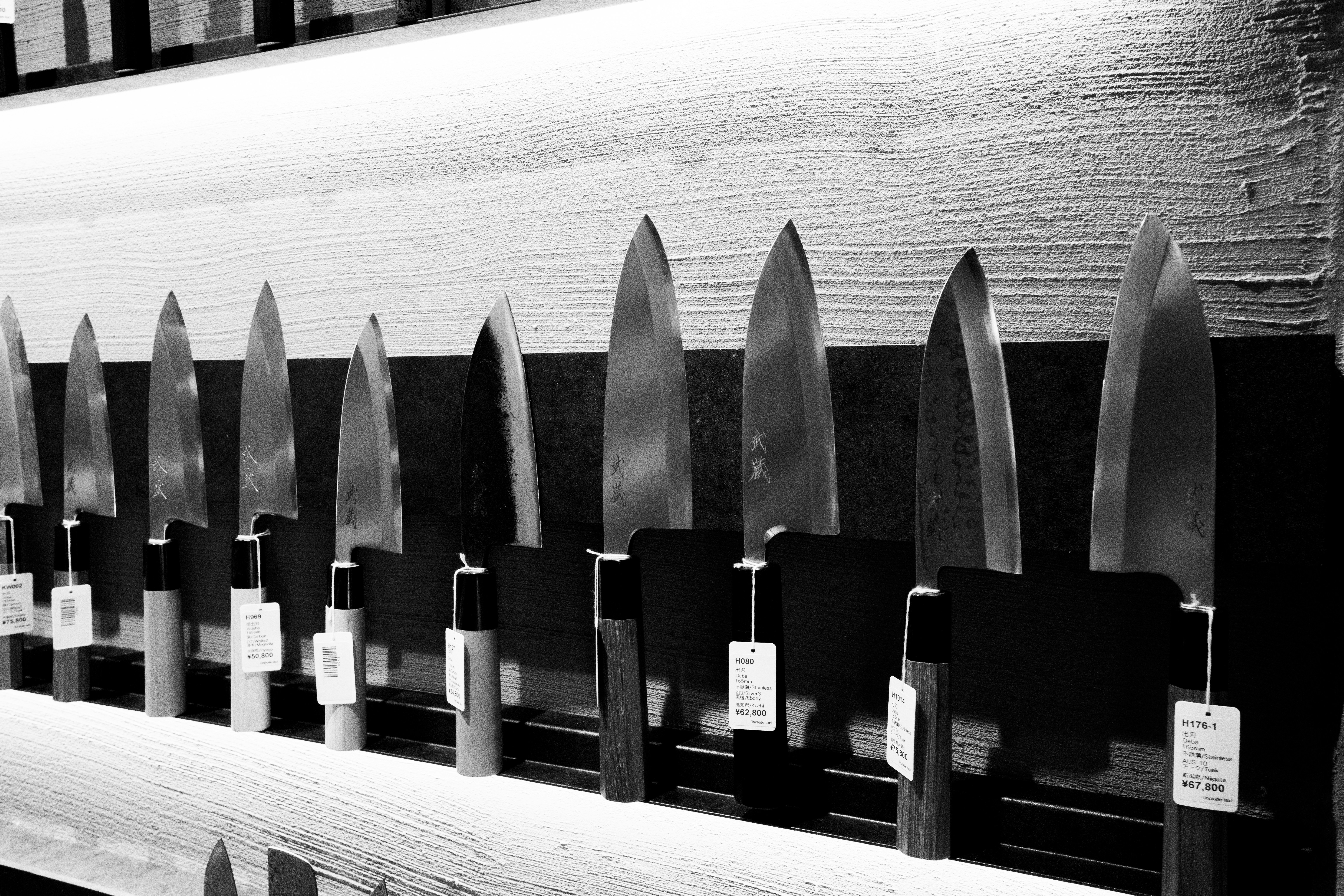 Row of Utility Blades on a Wooden Rack in Monochrome