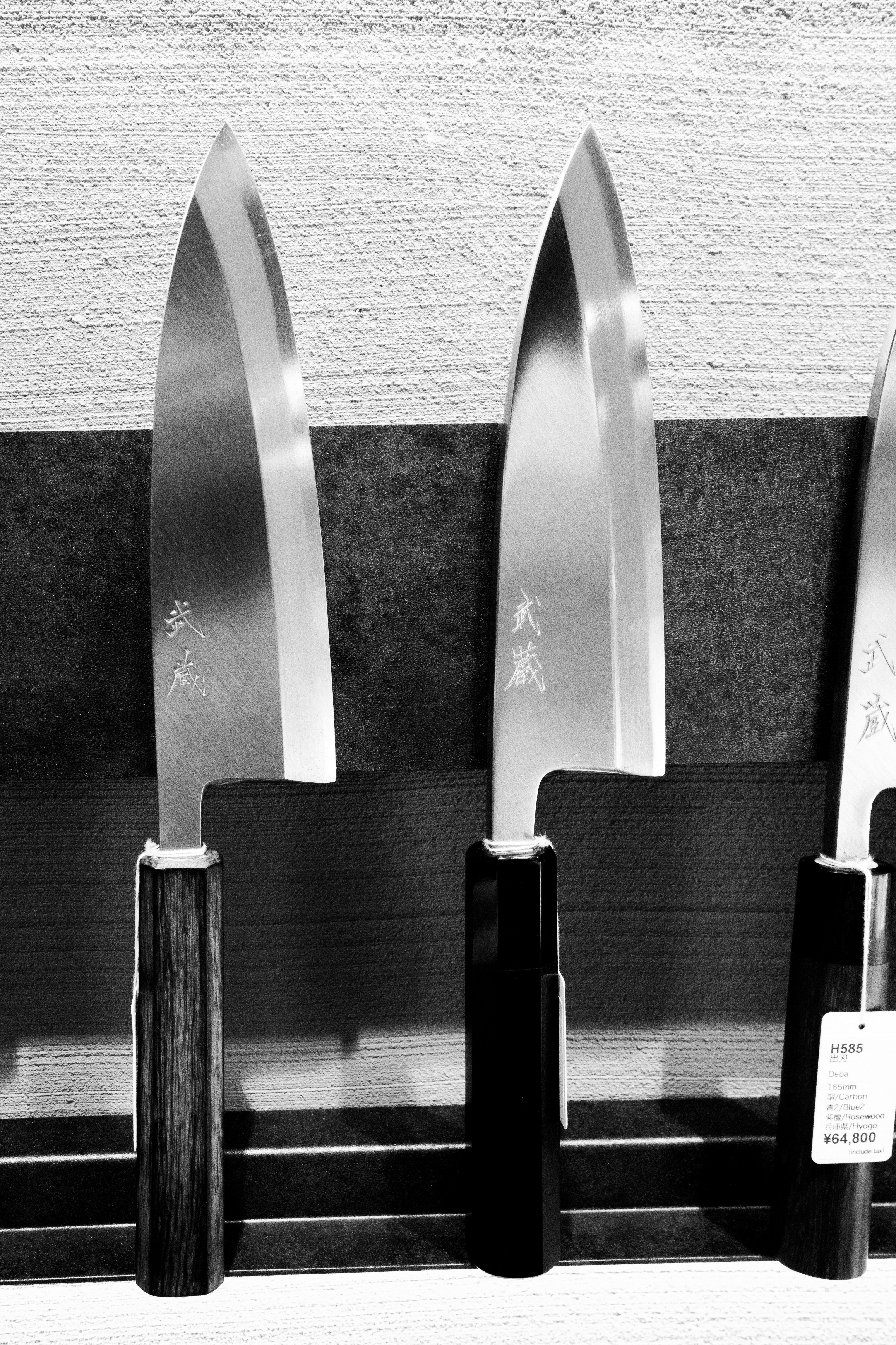 Double-edged Precision: A Row of Japanese Kitchen Knives Displayed in Steam-Backlit Studio