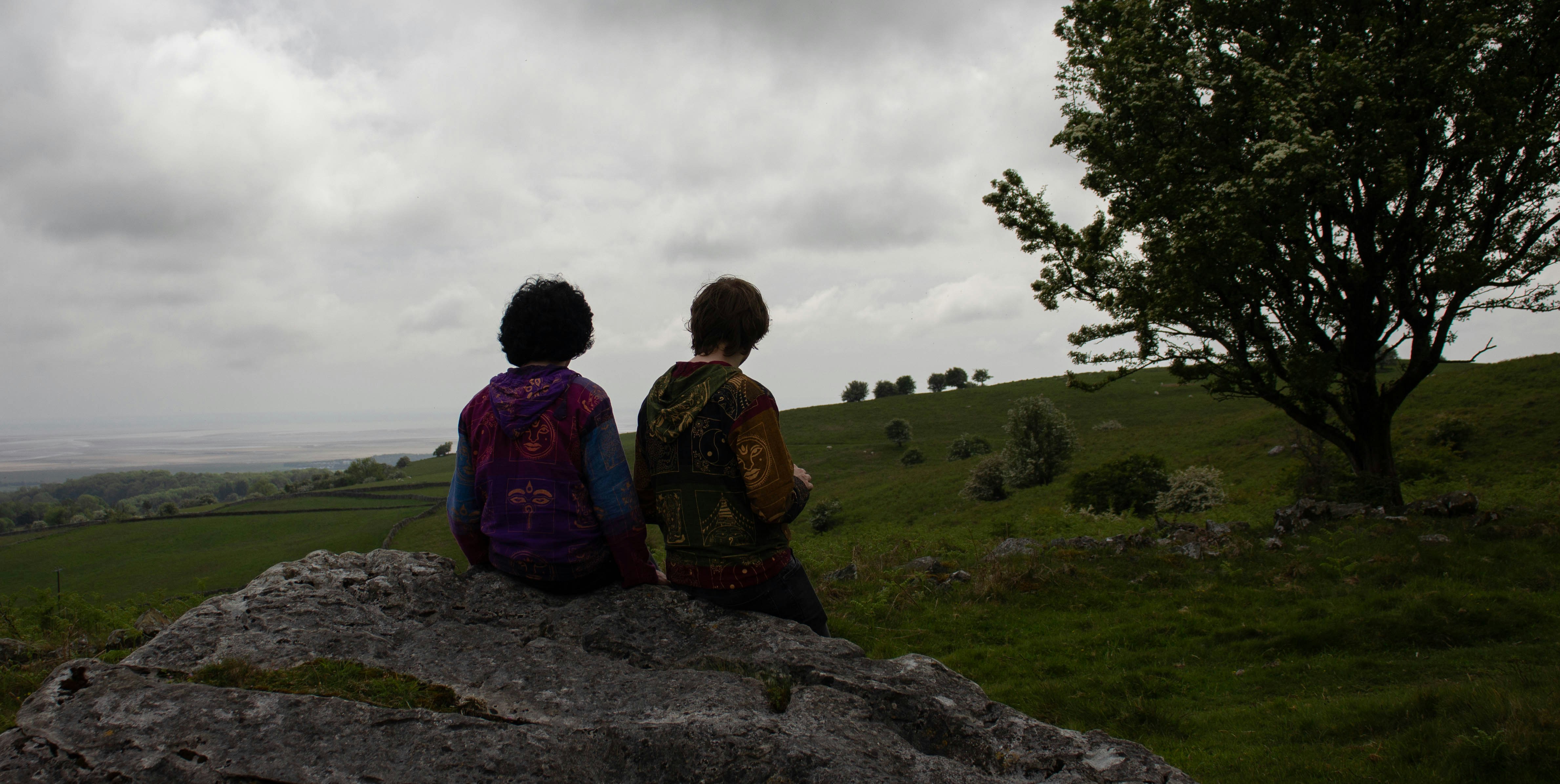 Two Hikers on a Quiescent Clifftop Overlooking a Rolling Landscape