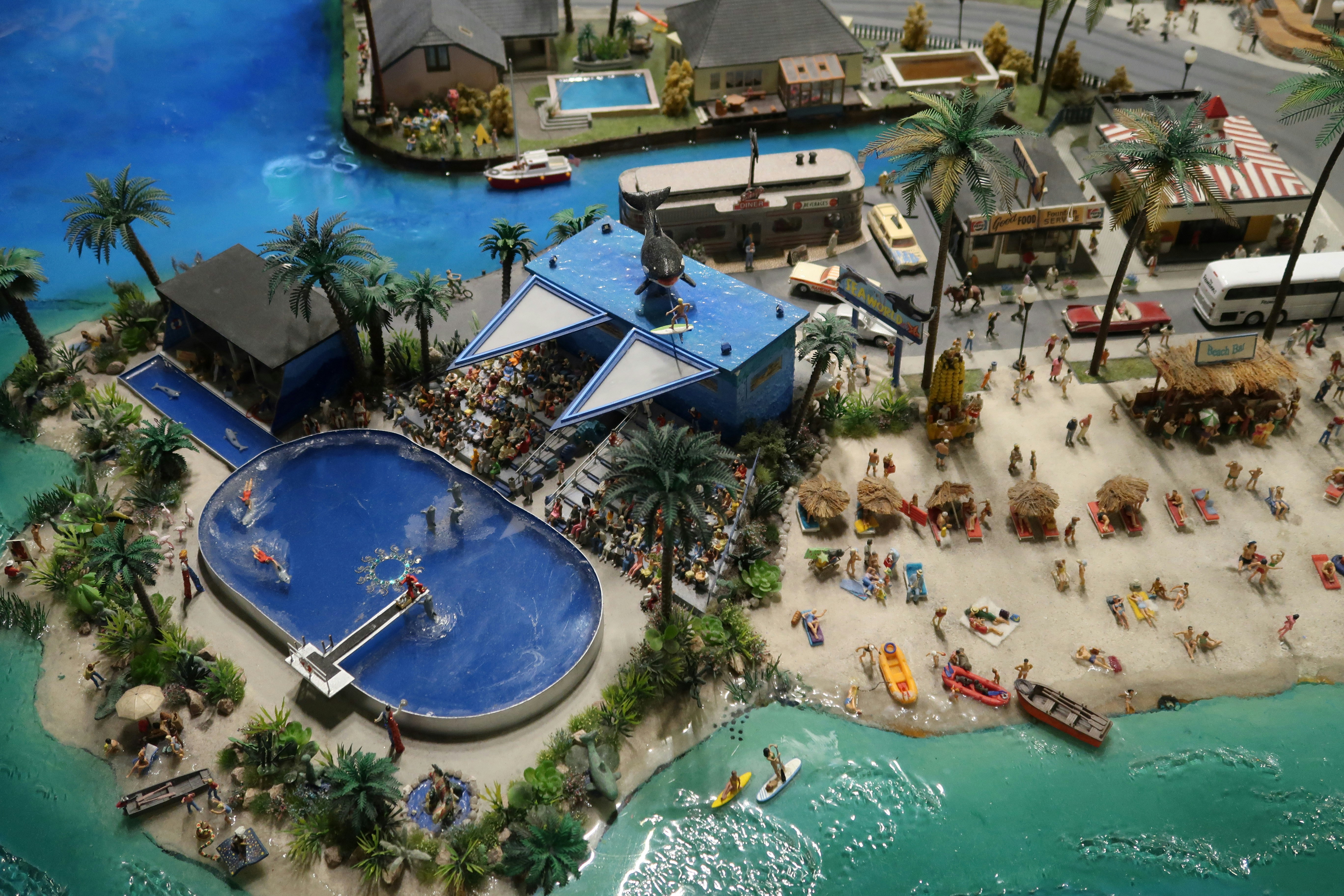 Miniature Beachfront Theme Park: Aerial Vantage of Pools, Shops, and Crowd