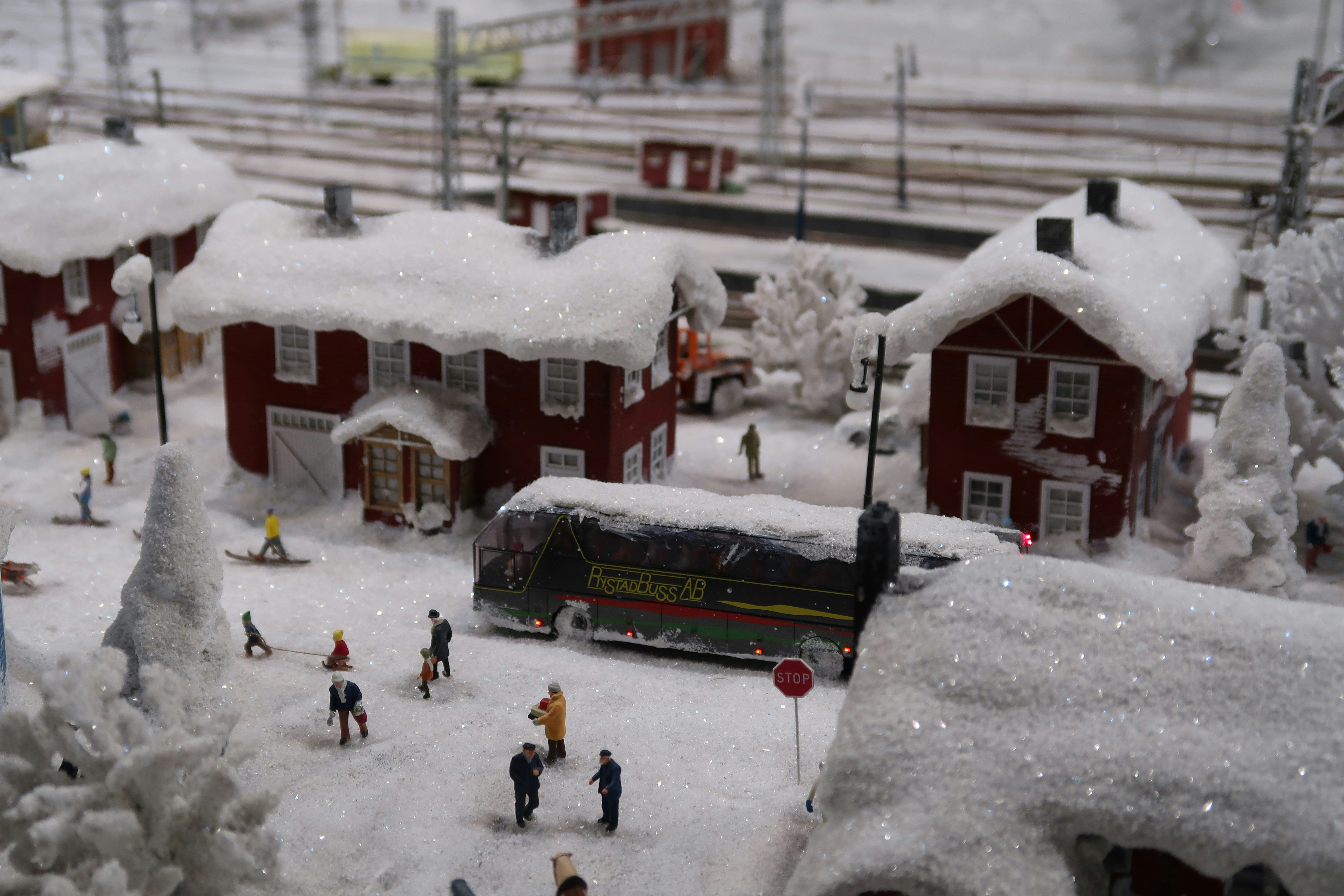 Miniature Winter Train Stop Under Snow-Covered Village