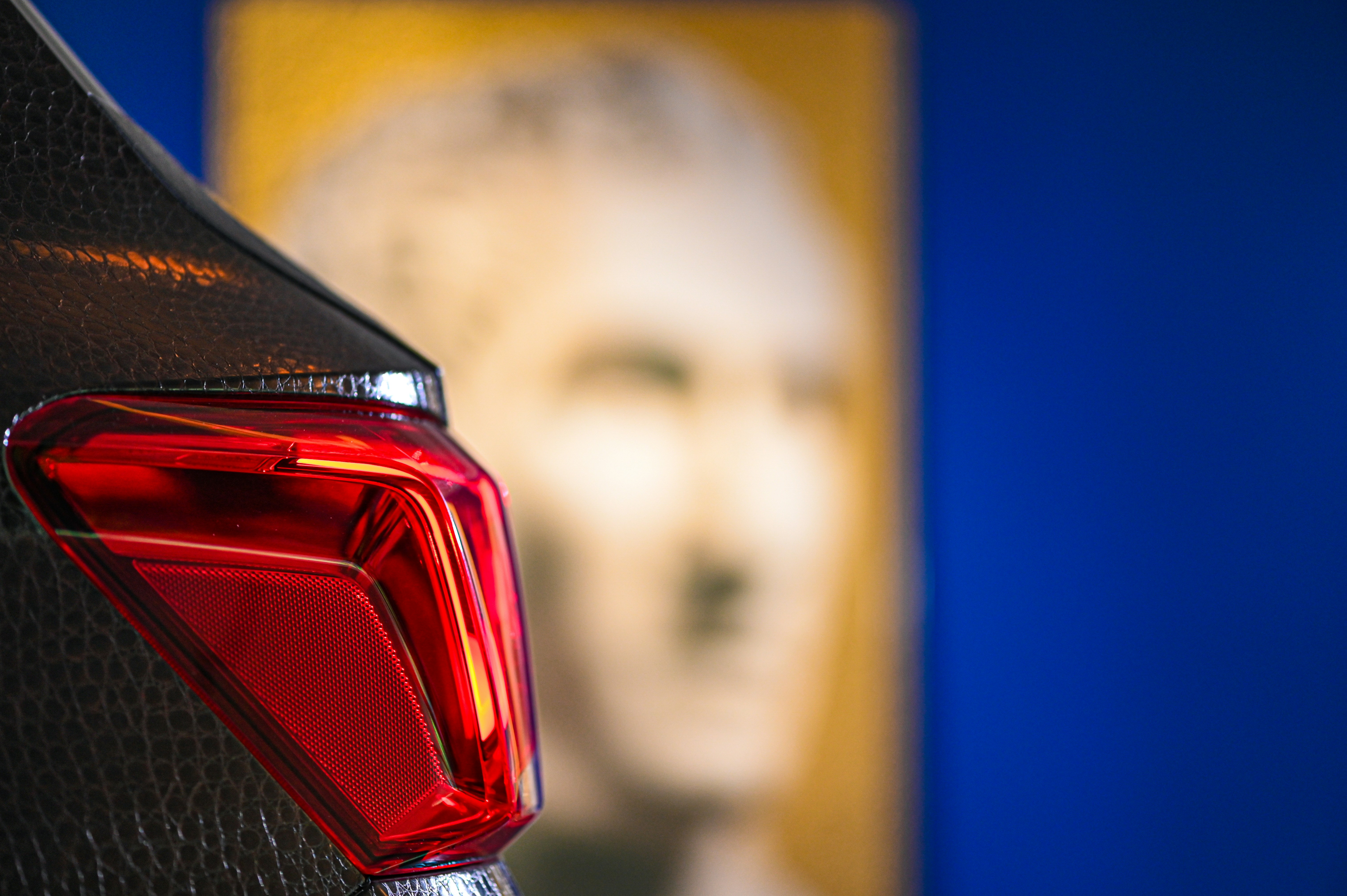 Red TAillight Echo: A Car's Edge Against a Blur of Blue