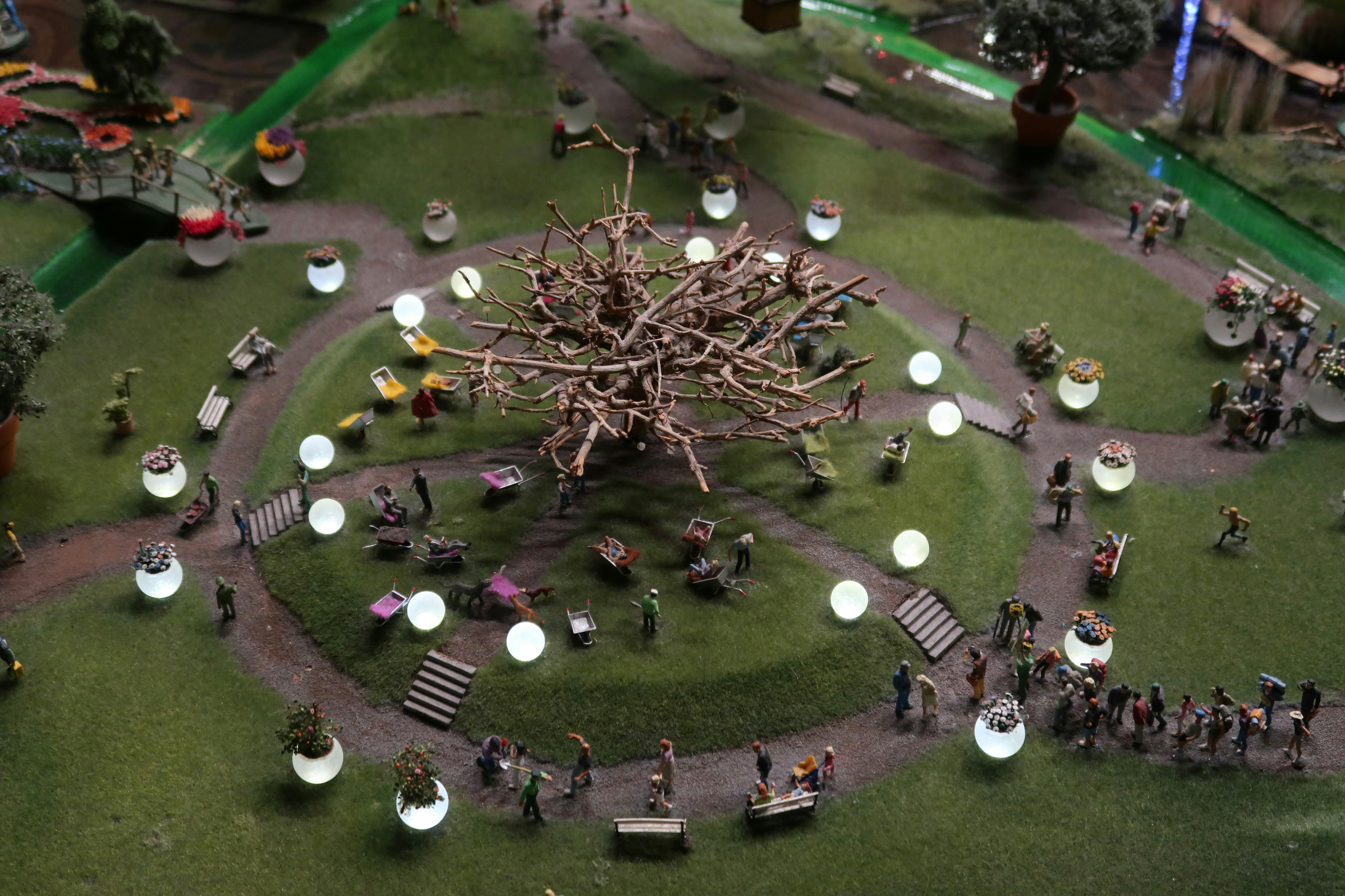 Miniature Piazza: A Tree centerpiece draws a crowd under tiny lamplight