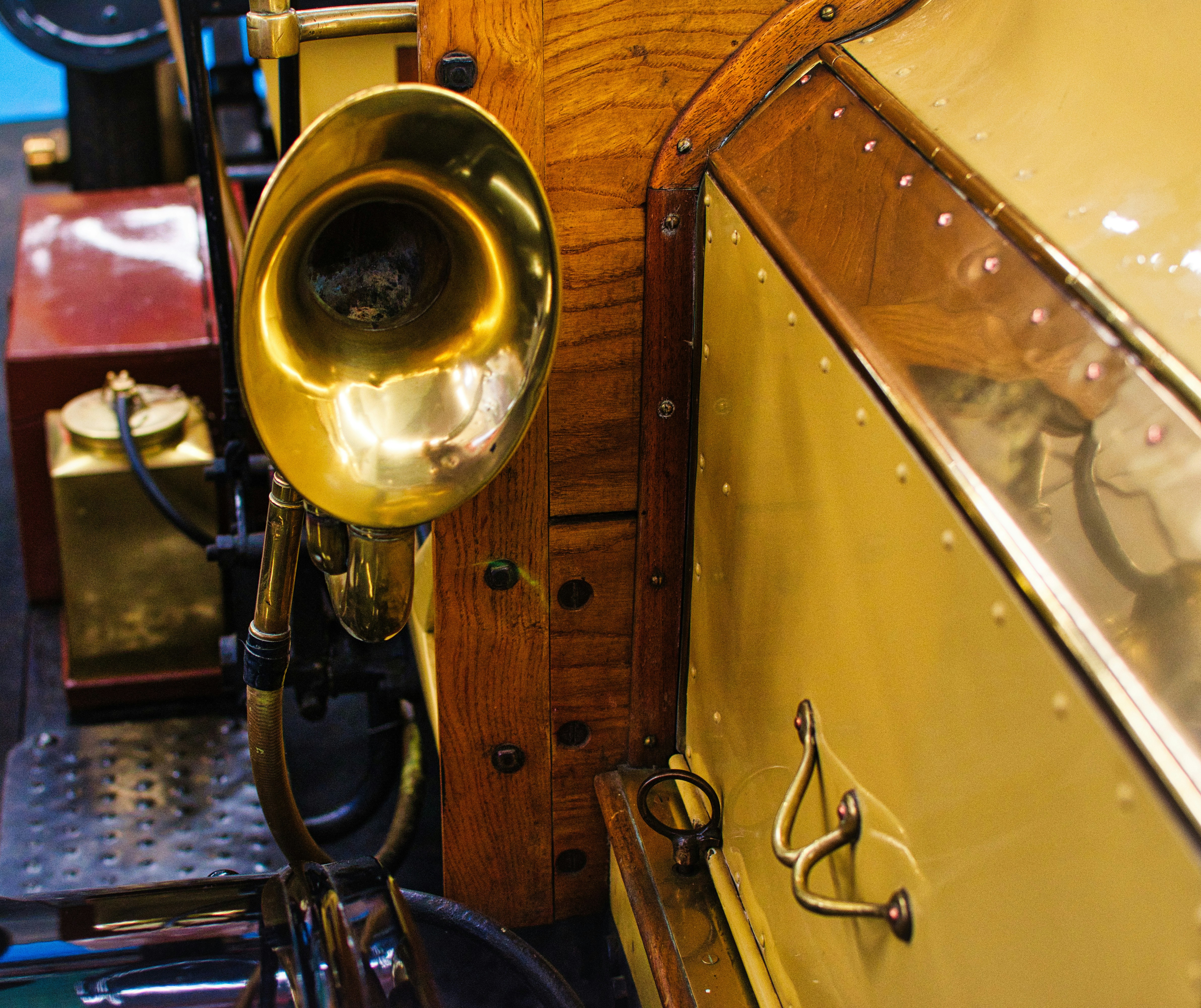 Brassy horn in a copper-and-wood cockpit of a vintage vehicle