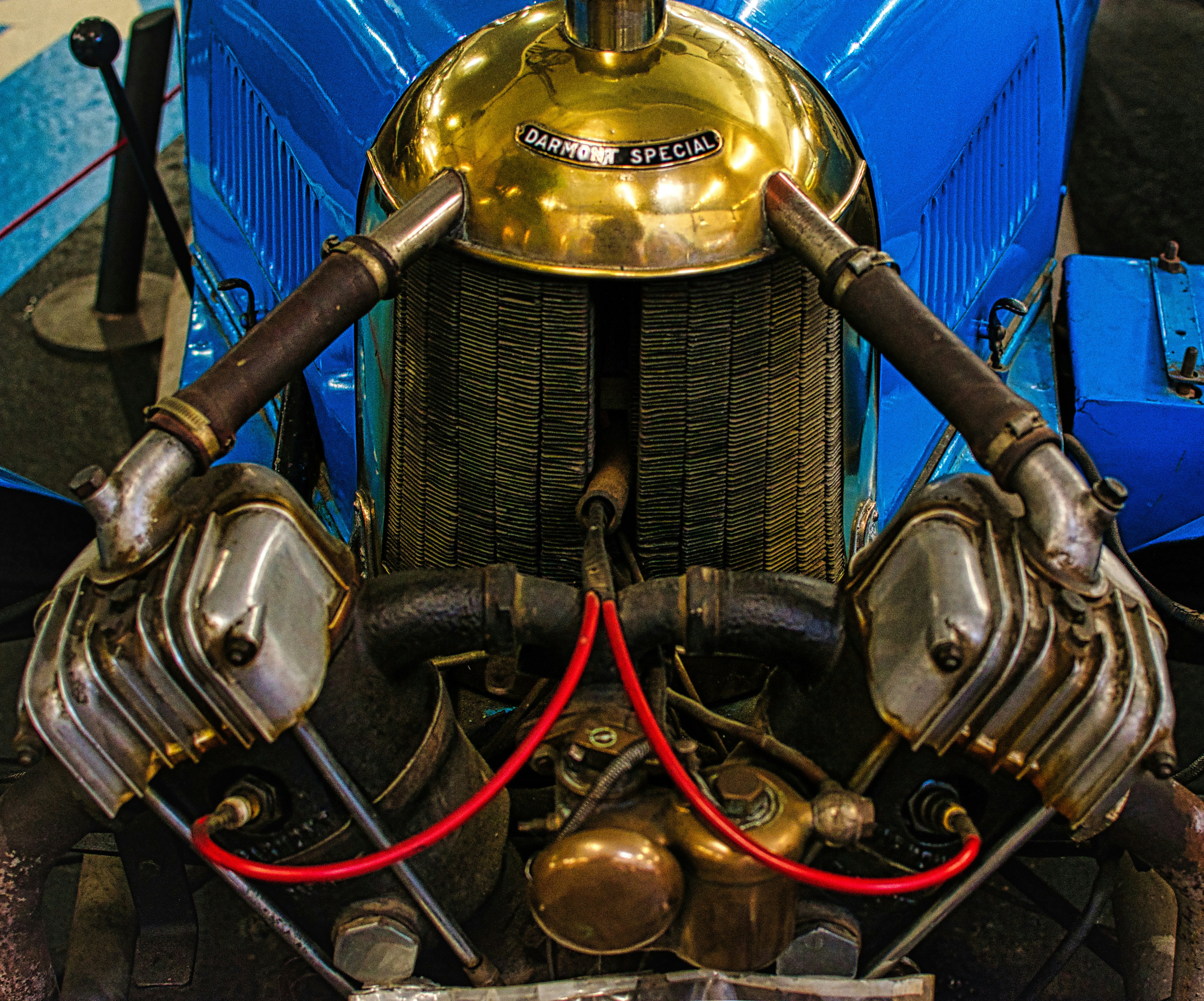 Close-up of a gleaming vintage car engine and brass radiator cap