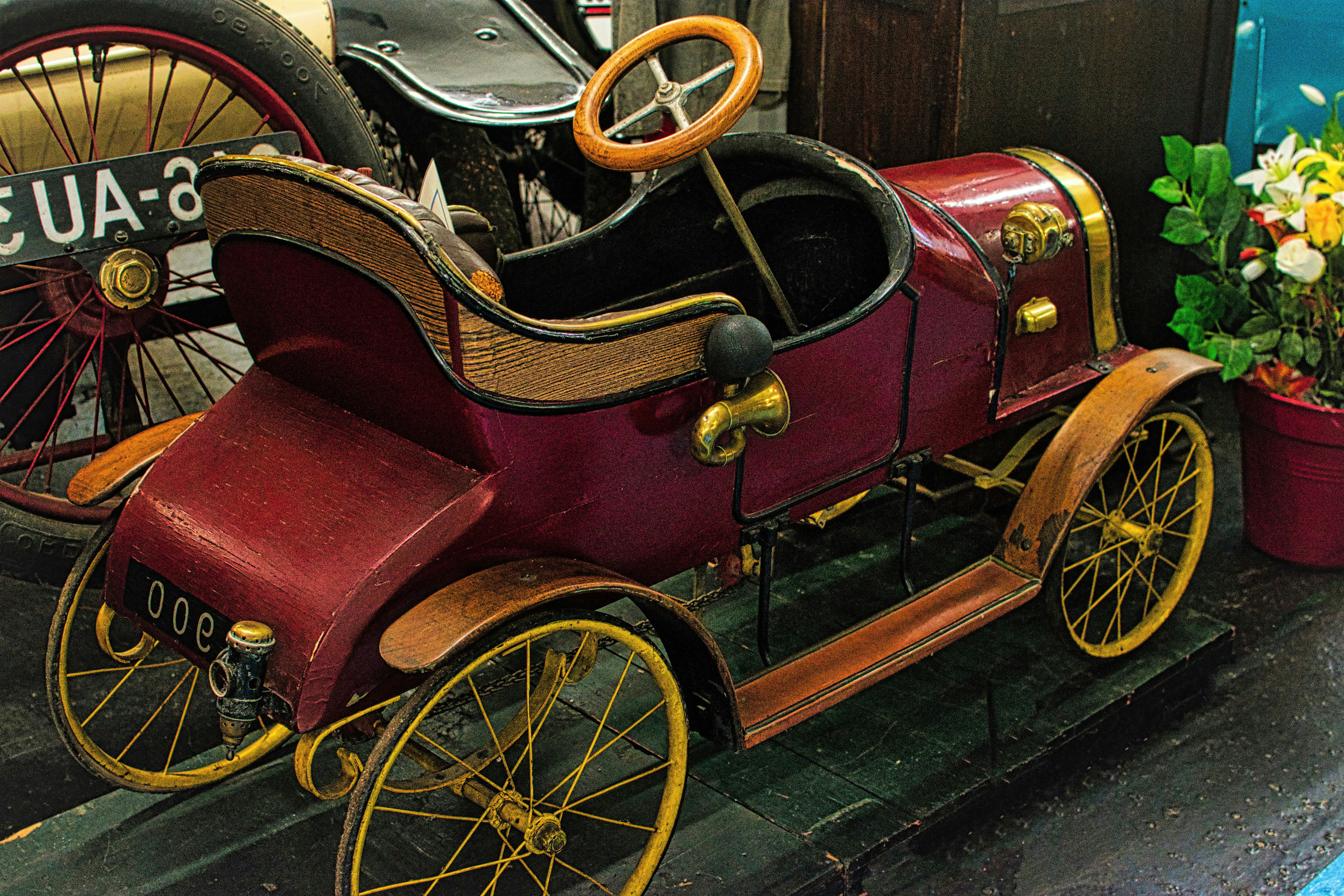 Golden Age Ride: a burgundy vintage toy car on display