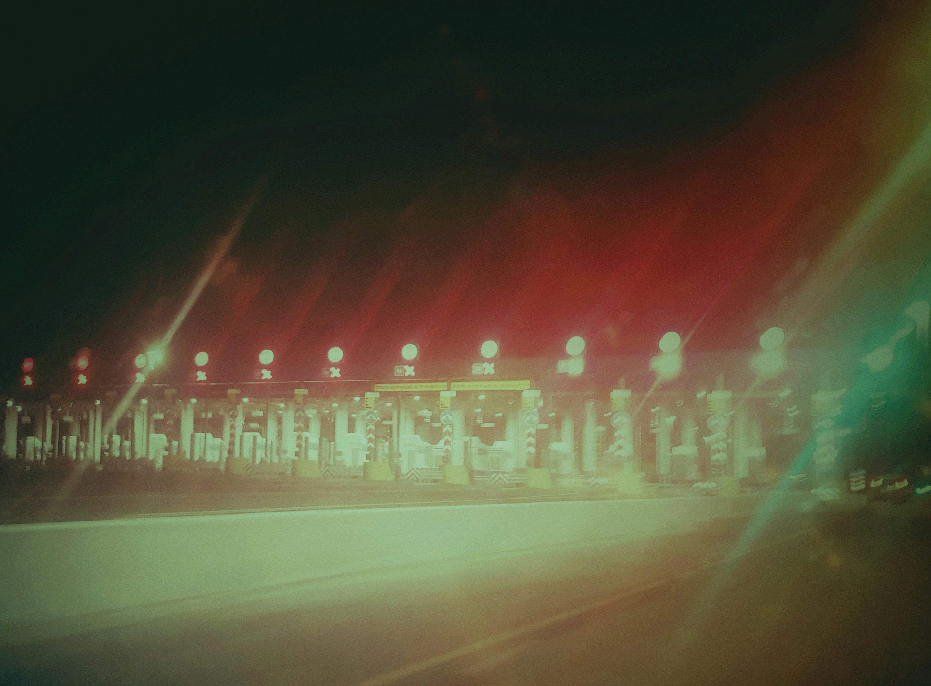 Blurry night scene with red and green light flares.