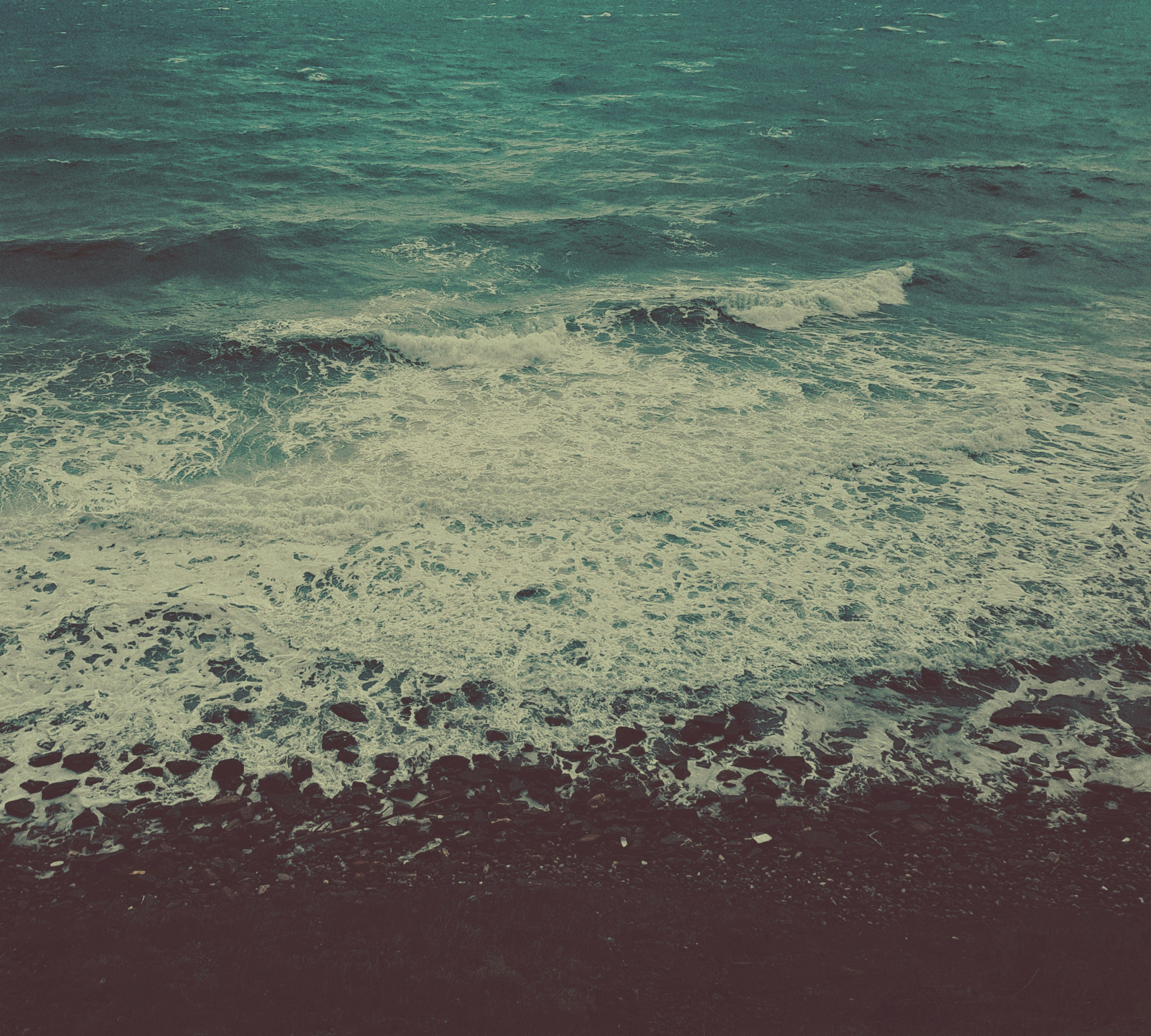 Rough Seas at Dusk: Foam Lines Meeting a Quiet Shore