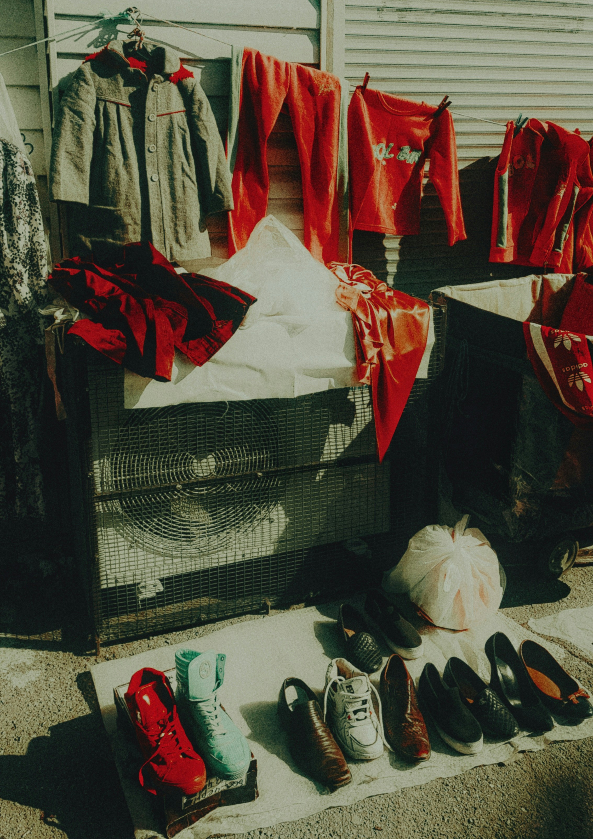 Urban Vestibule: Shoes Beneath an Alley of Red Garments