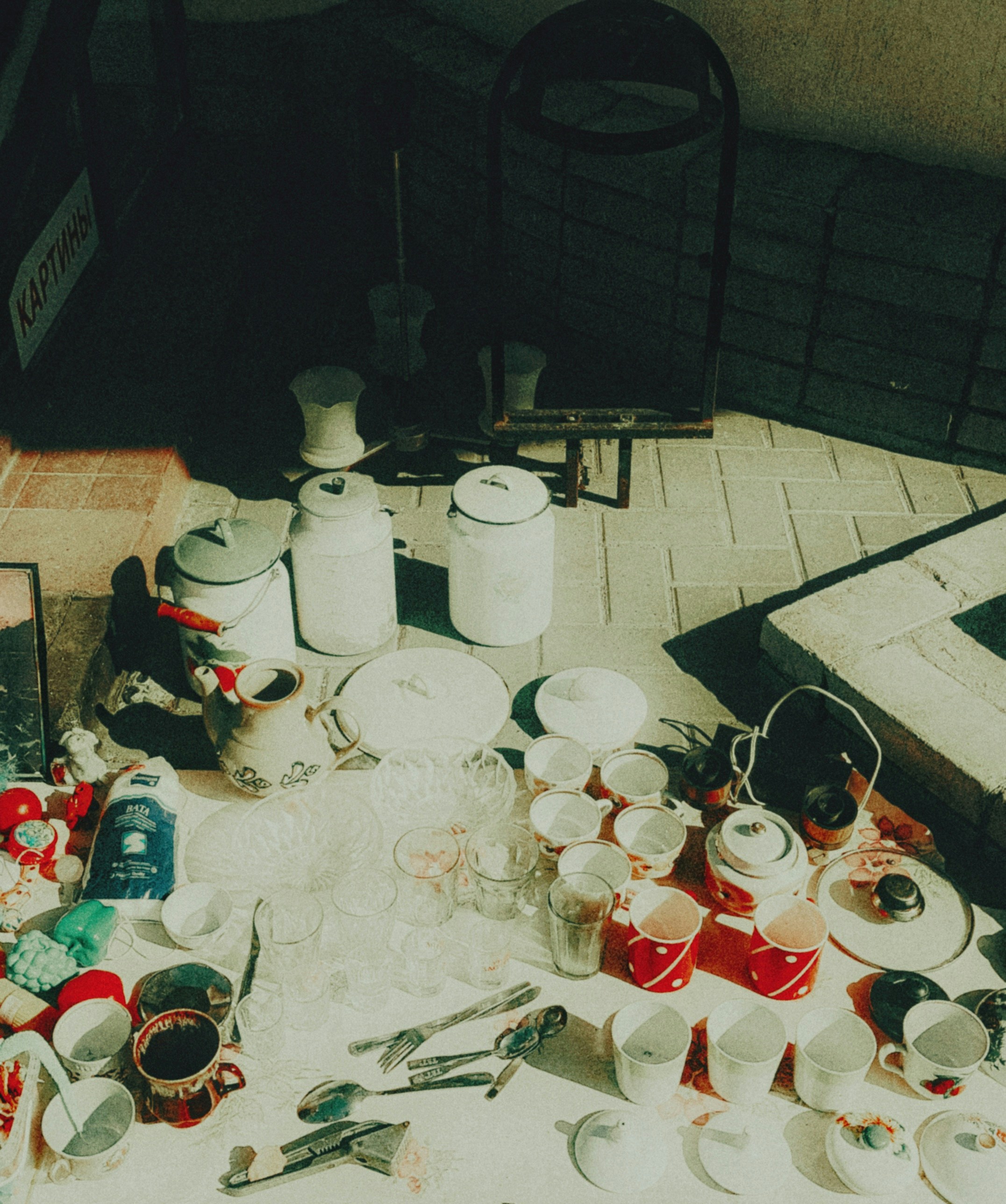 Sunlit Bazaar Still Life: A Cluttered Table of Mugs, Pots, and Tools