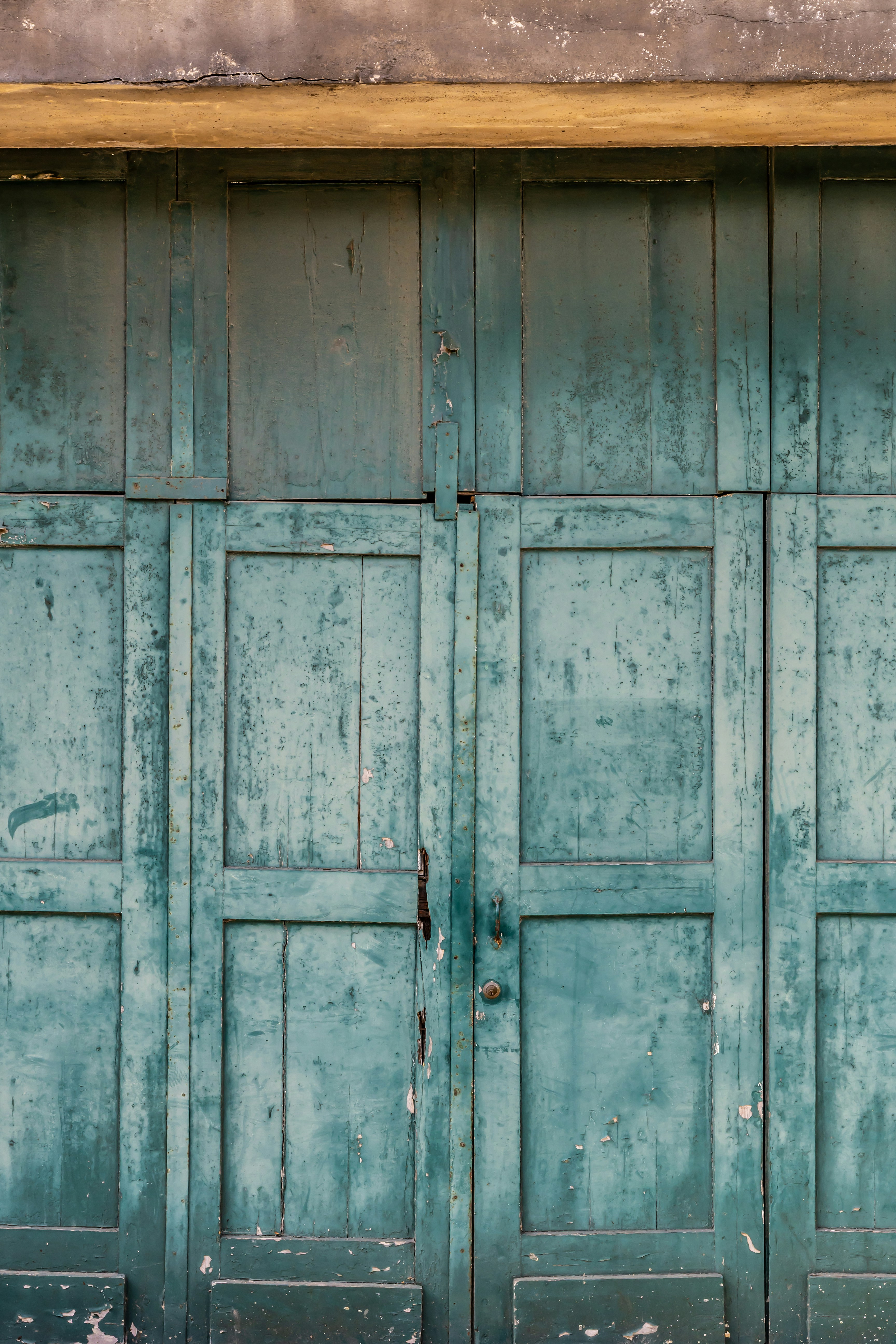 Weathered Teal Doors: A Quiet Facade of Aged Wood and Patina