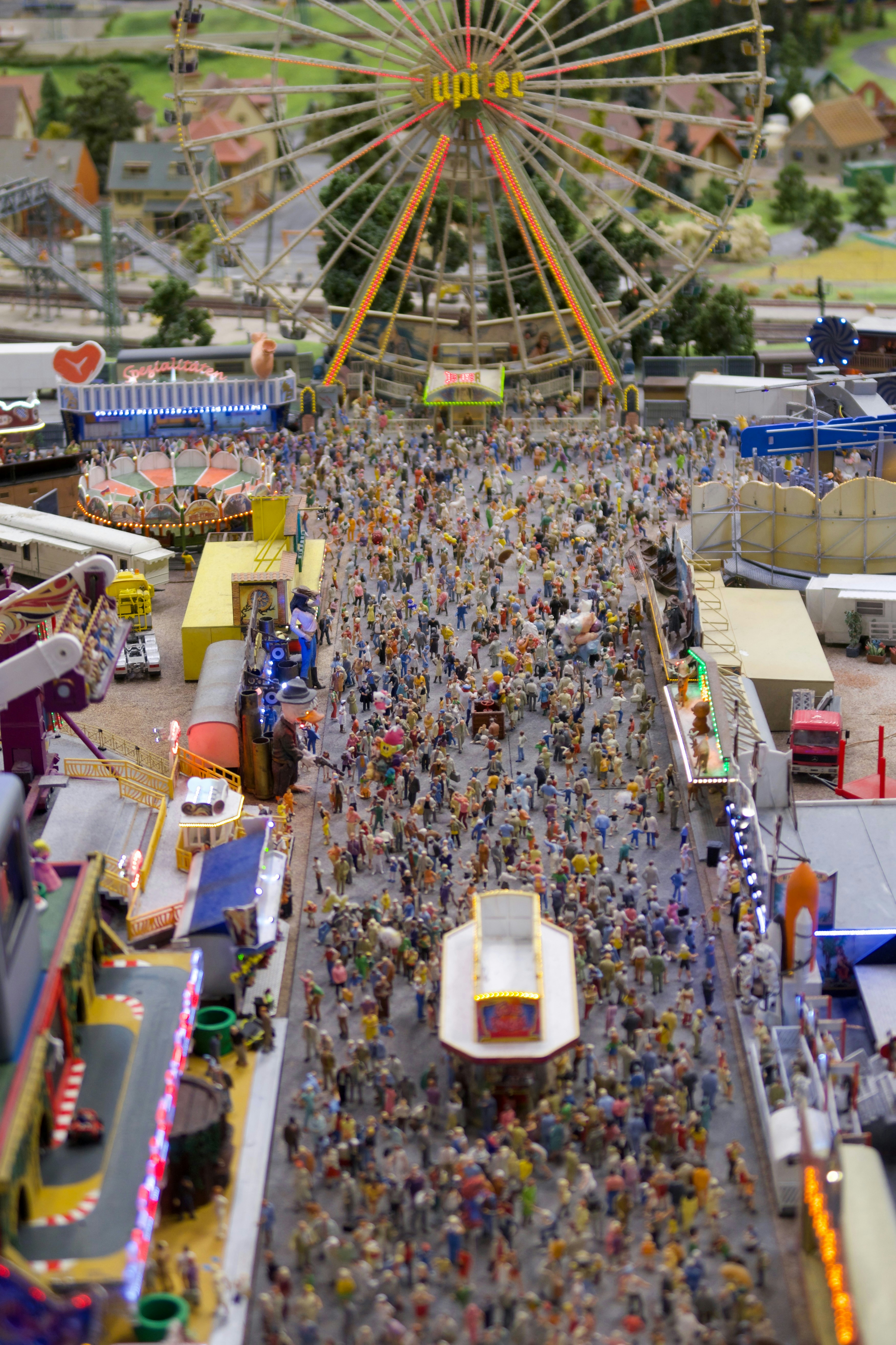 Miniature Carnival: A Distant Street of Tiny People and a Grand Ferris Wheel