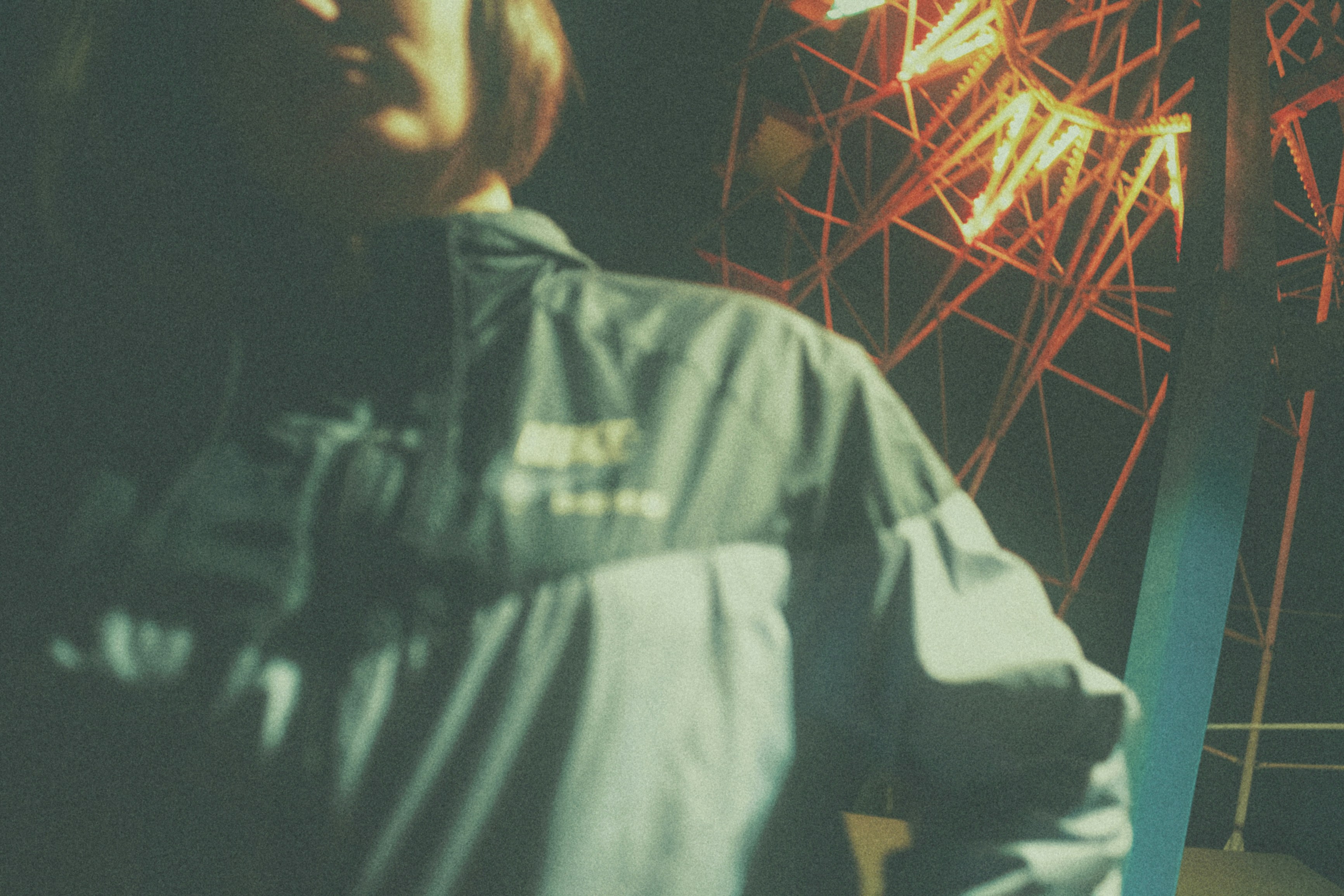 Backlit Encounter: A silhouette of a jacketed figure under neon lattice