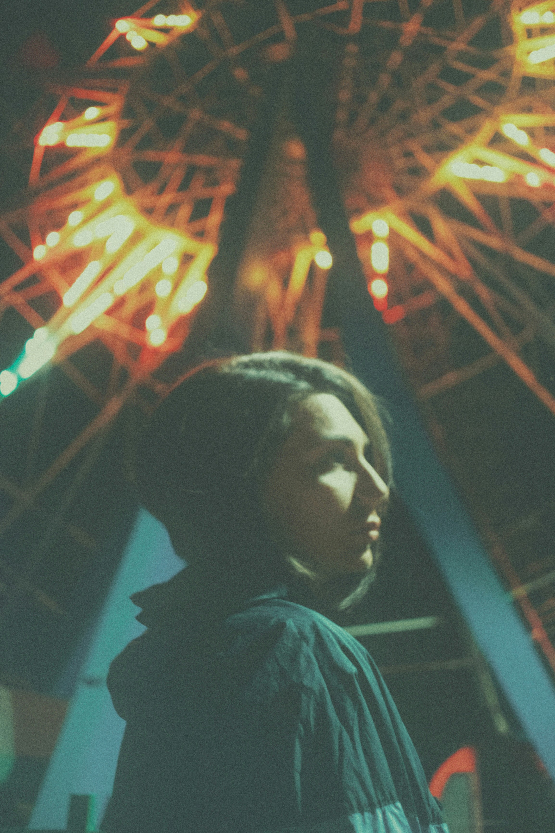 Night frame: Portrait under Ferris glow in an urban park