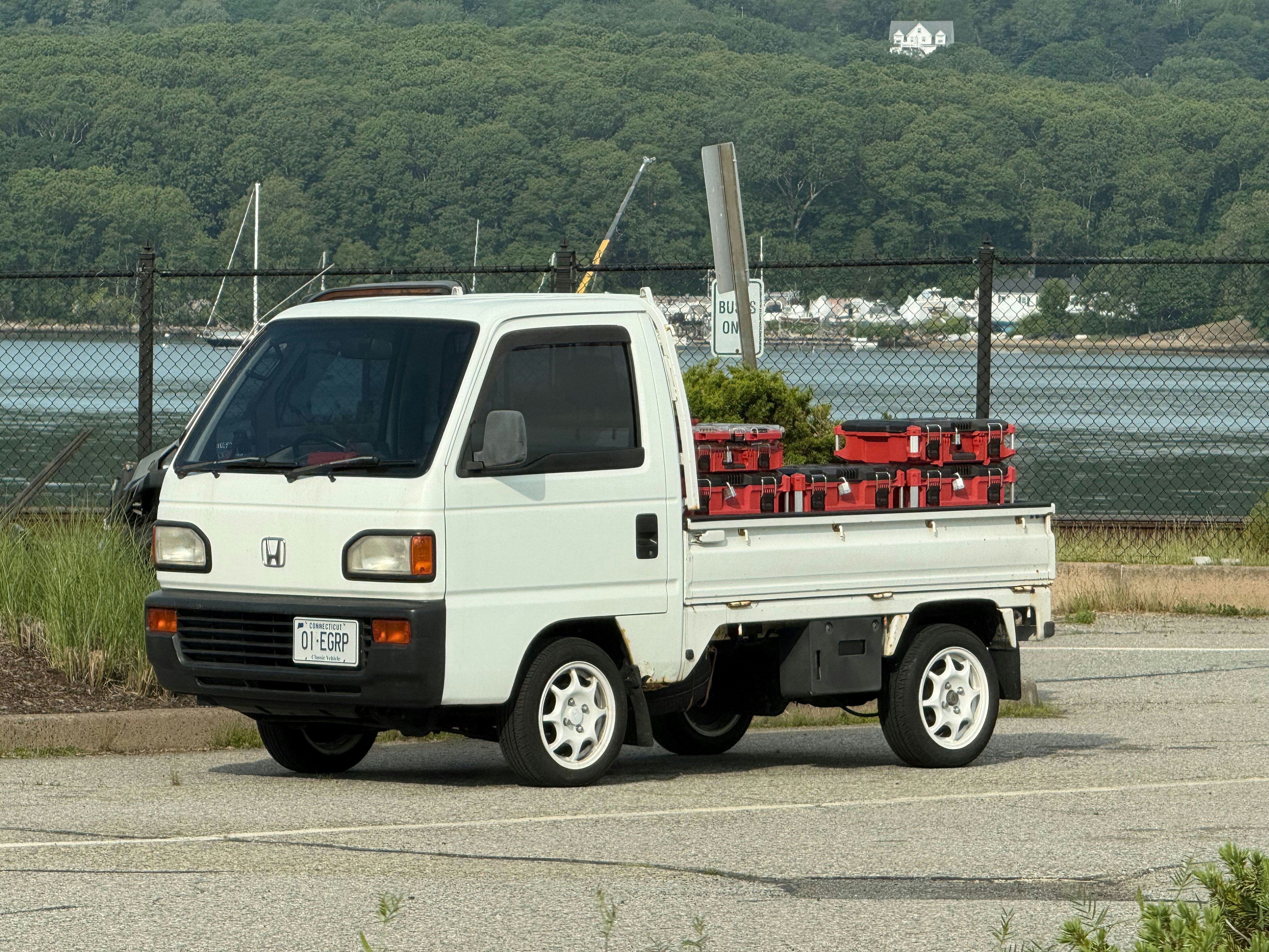 White utility truck with red tool crates at waterfront