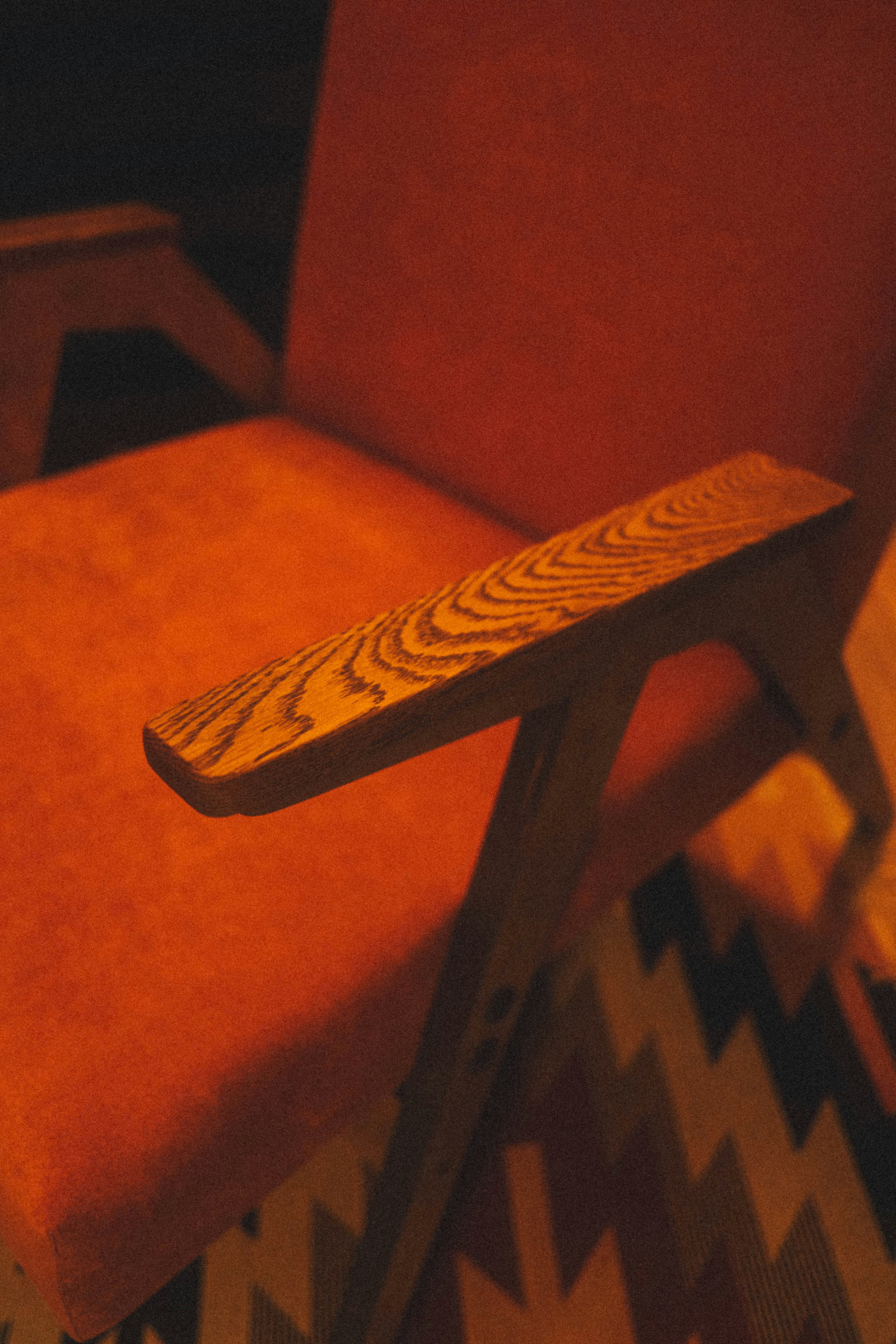 Warm Amber Armrest: A Close-Up of Textured Wood in Dim Light