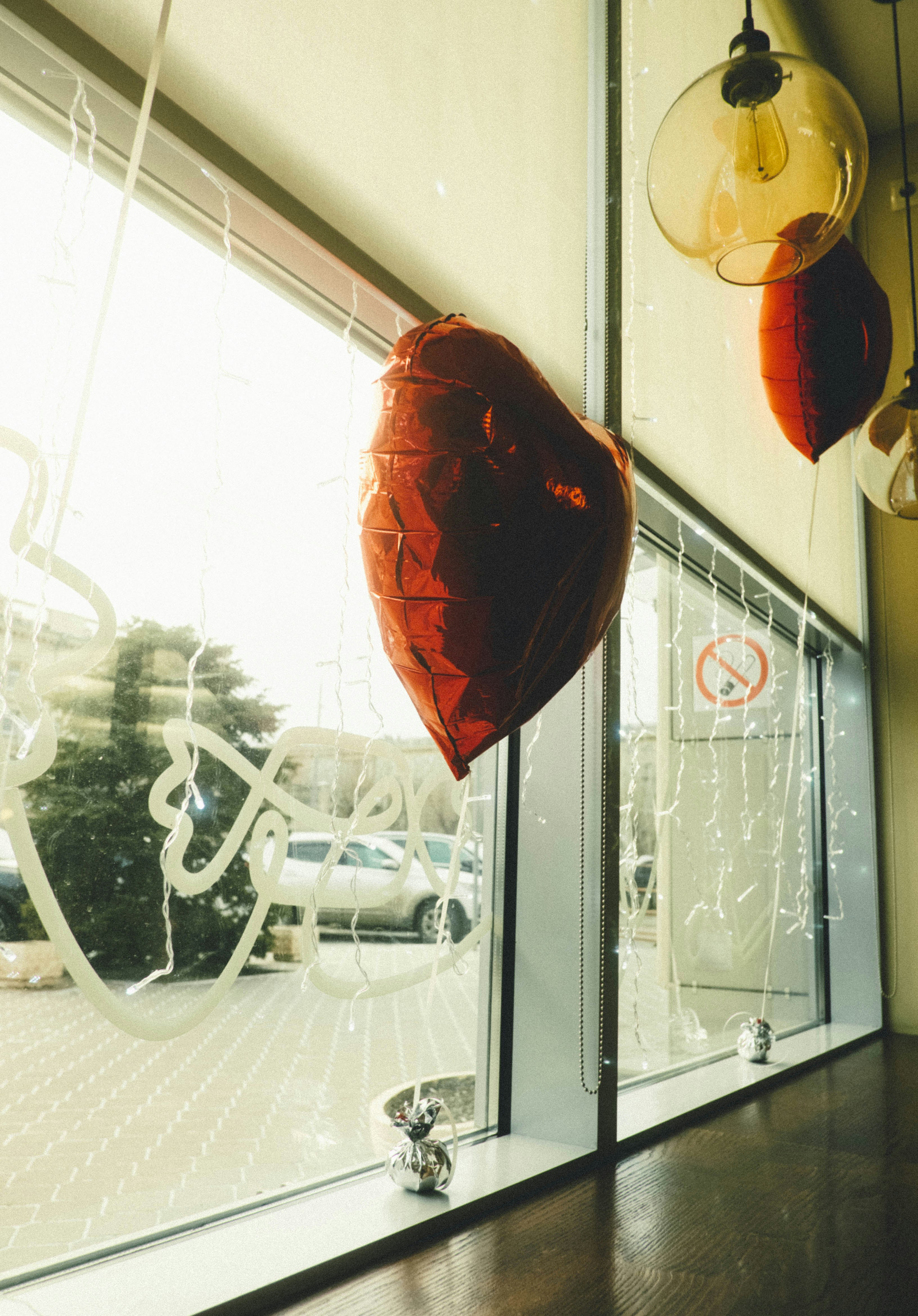 Floating Heart: Red Helium in a Bright Bistro Window