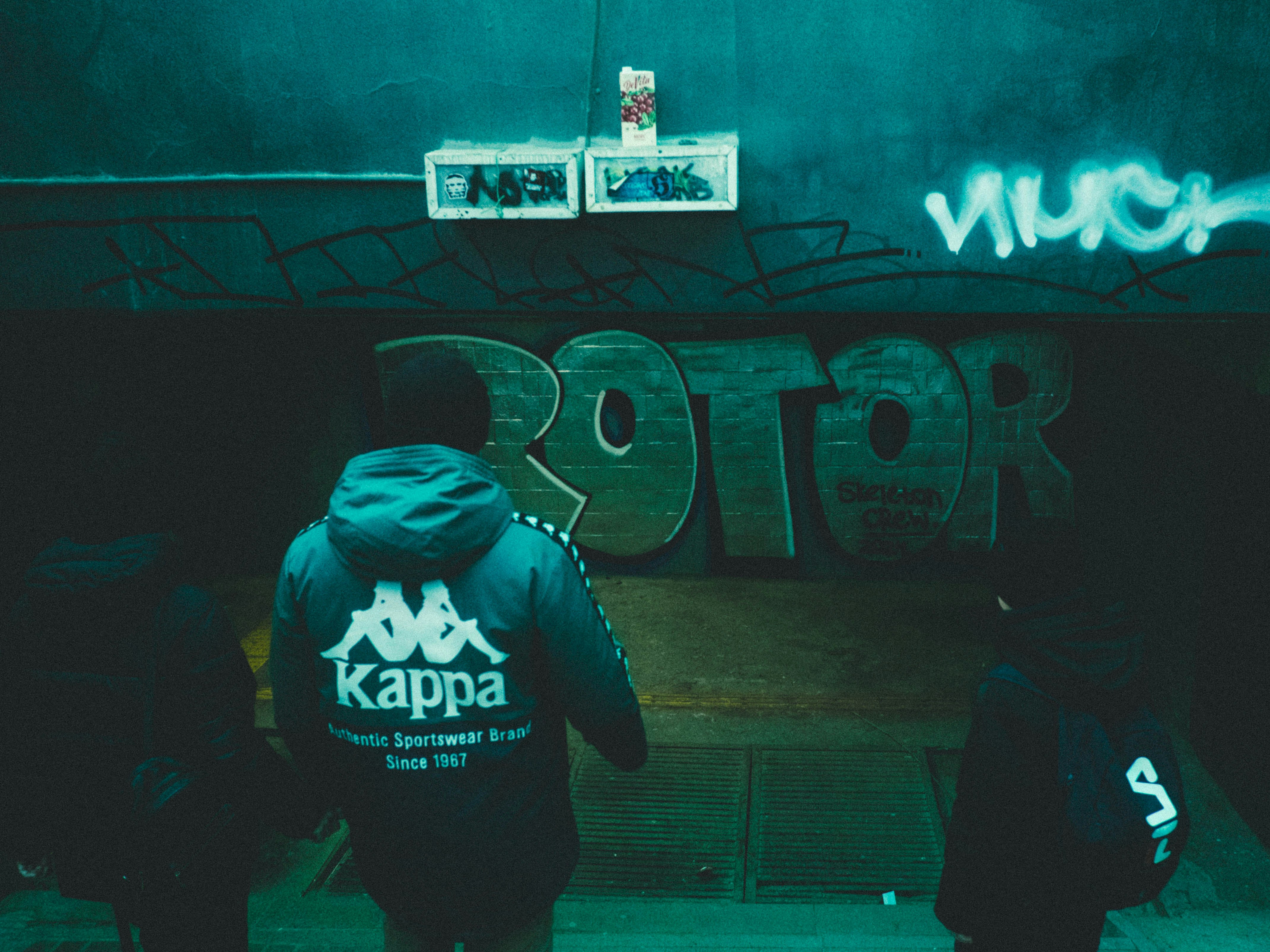 Hooded Figure in Graffitied Underpass
