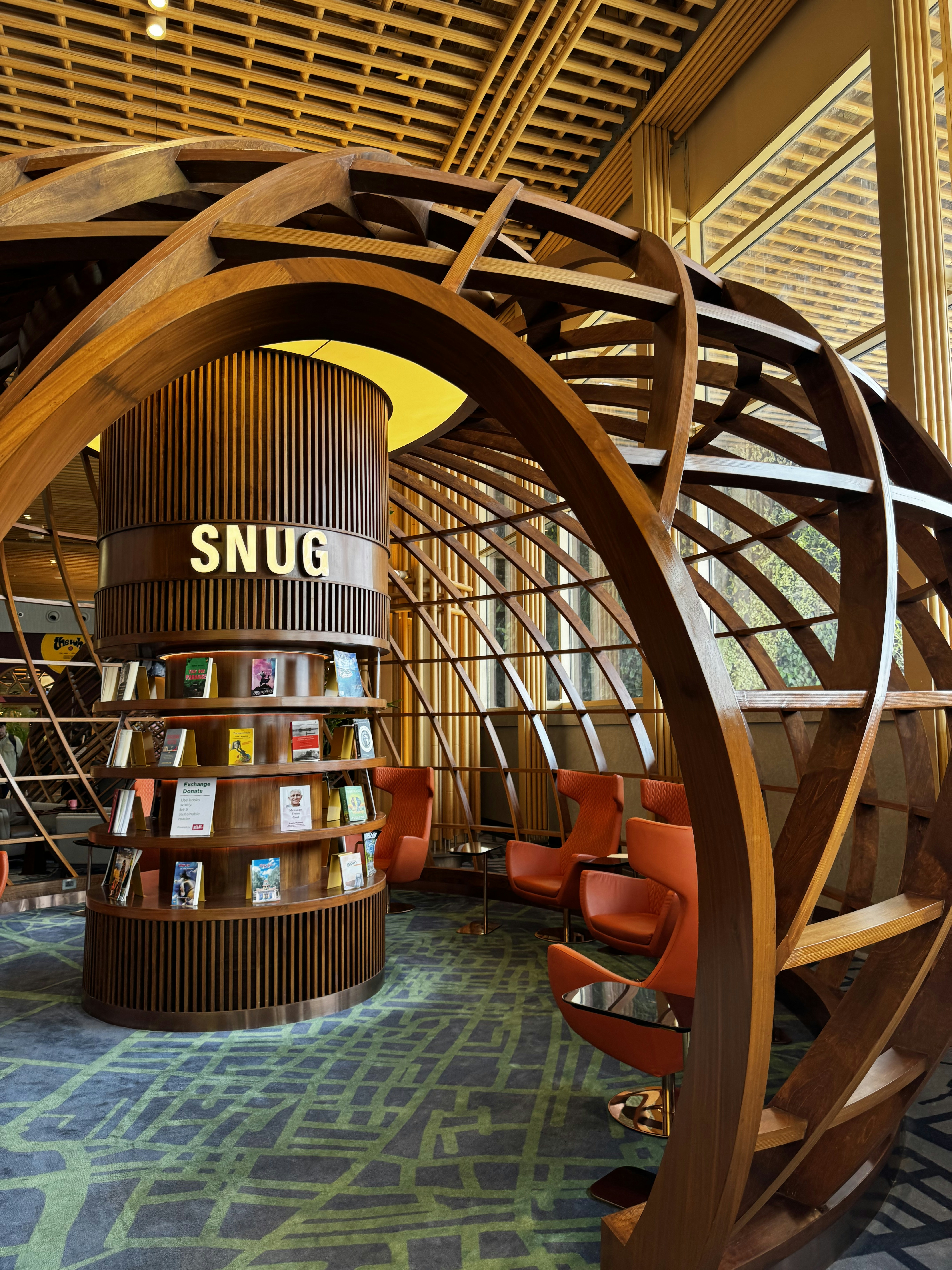 Circular wooden arcade: a cozy library nook encircling a central SNUG bookshelf