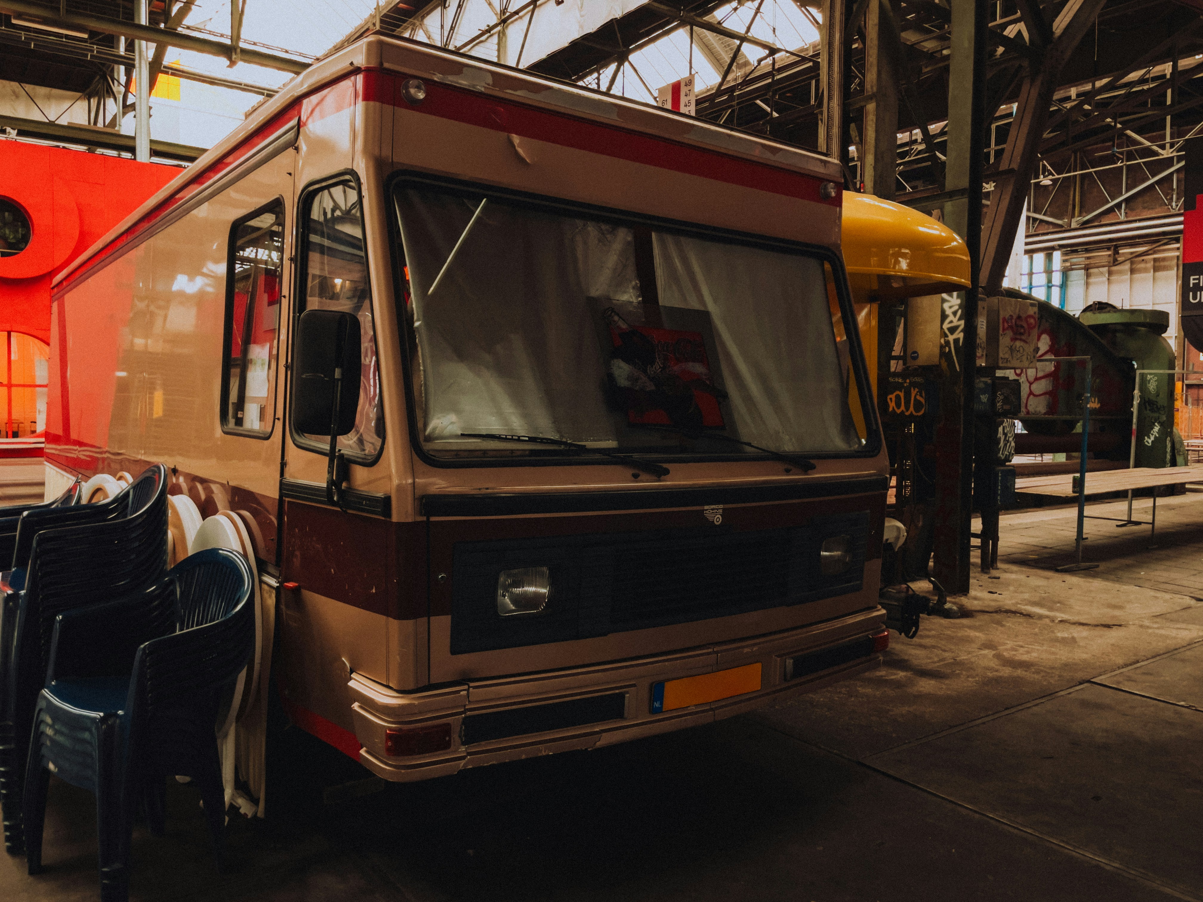 Midday Standstill: A Vintage Food Truck Bus in an Industrial Hall