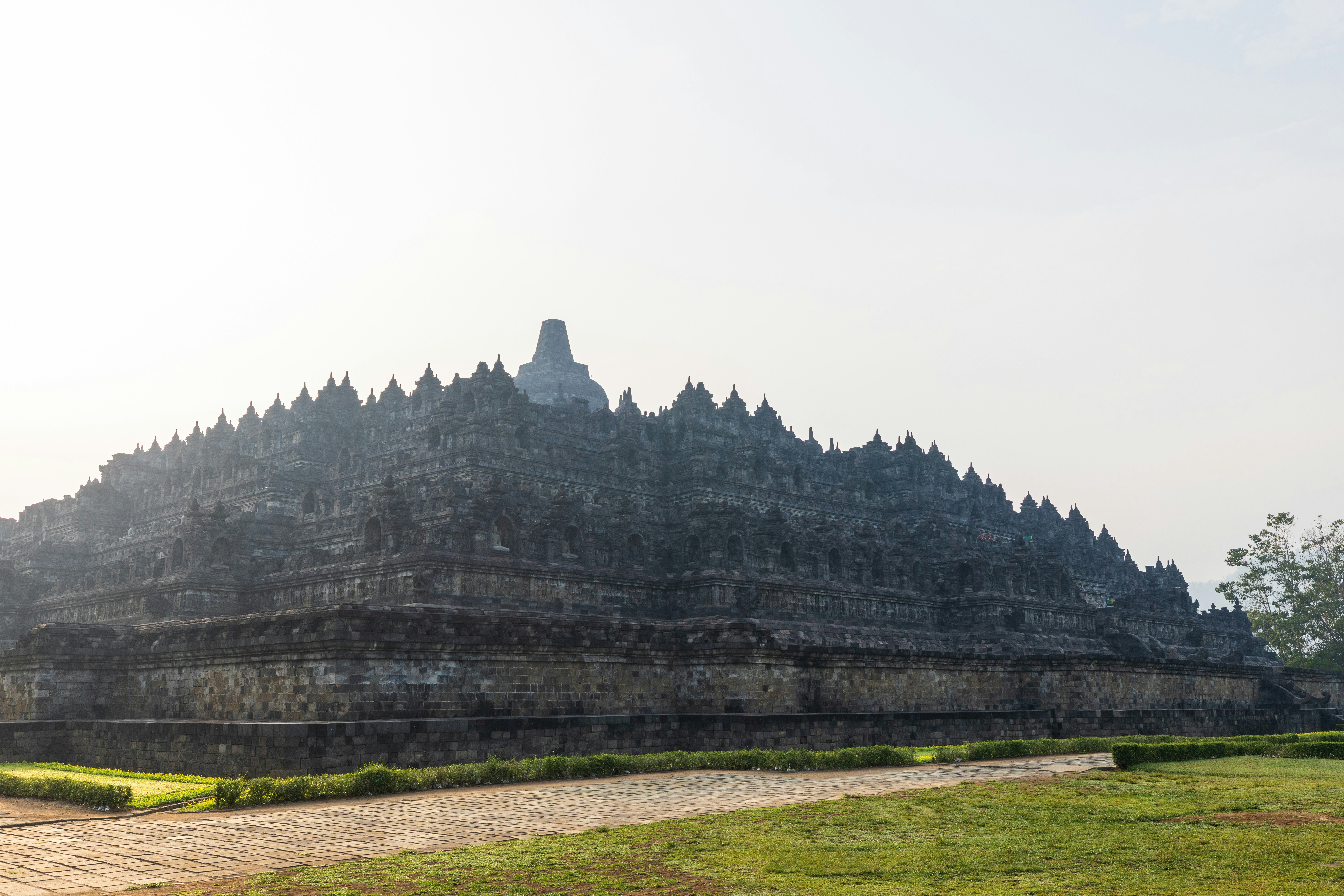 Ancient stone temple with multiple stupas under a clear sky.