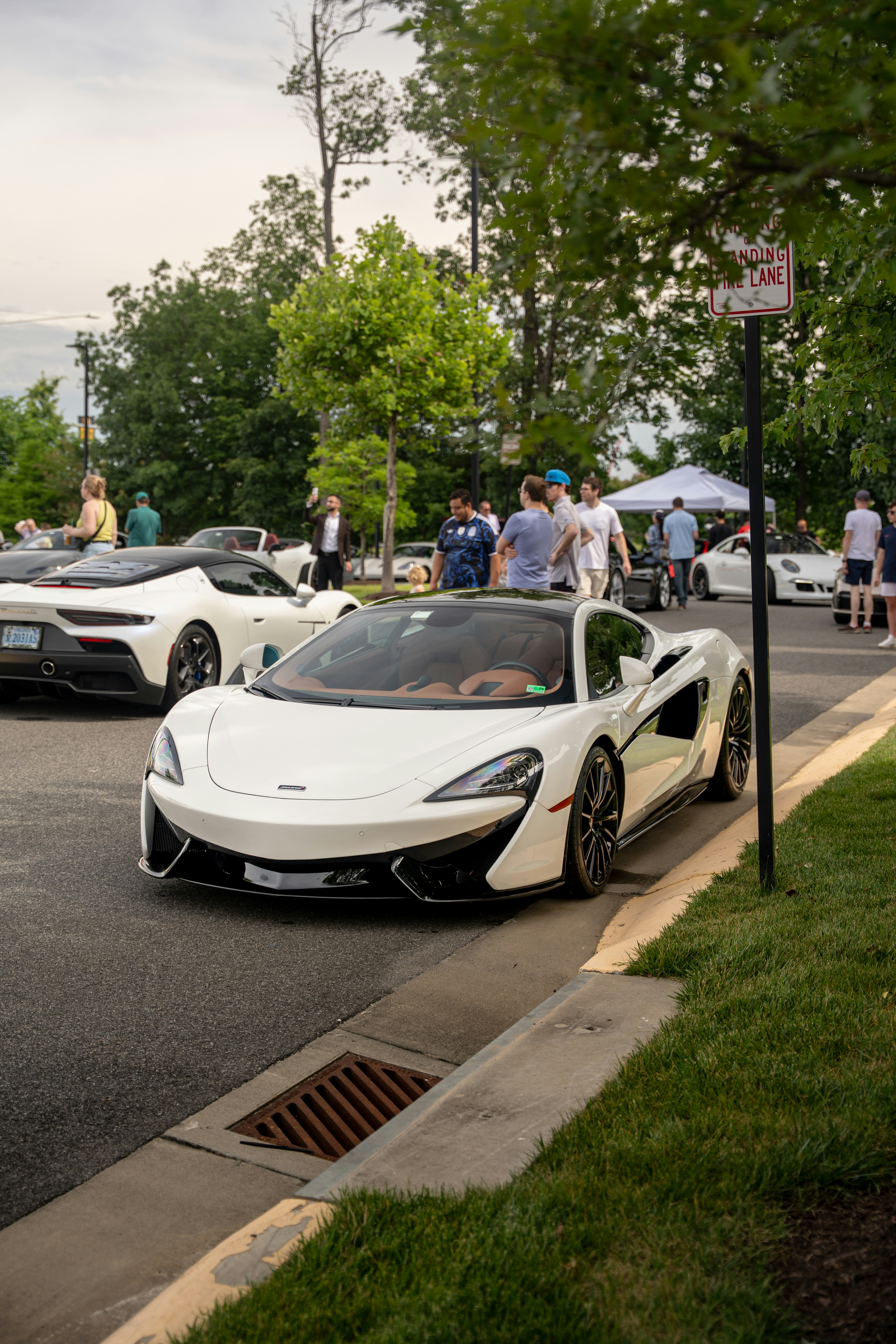 White McLaren at a car meetup: curbside elegance and onlookers