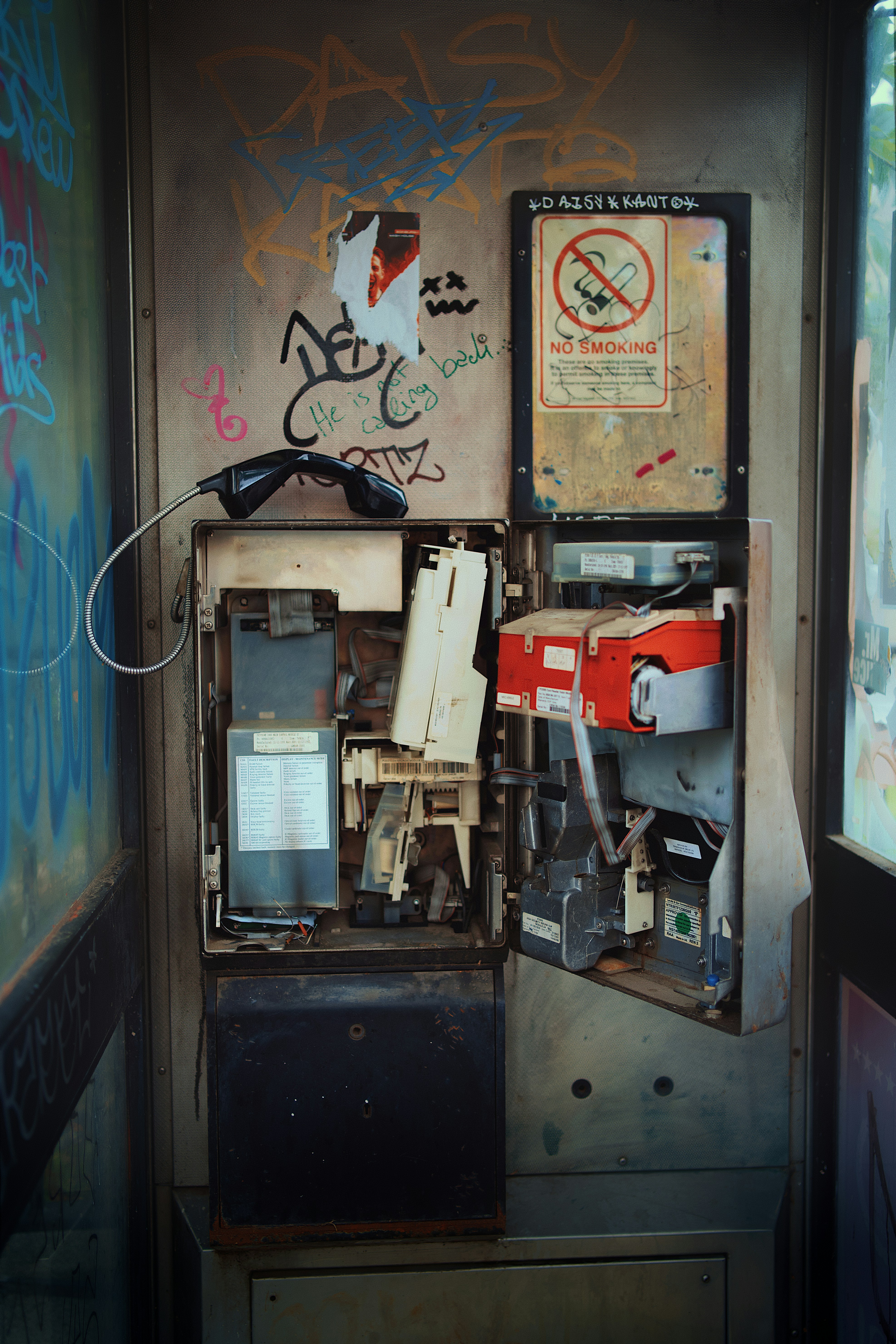 Discharged Neon: A Cluttered Service Panel Amid Graffiti
