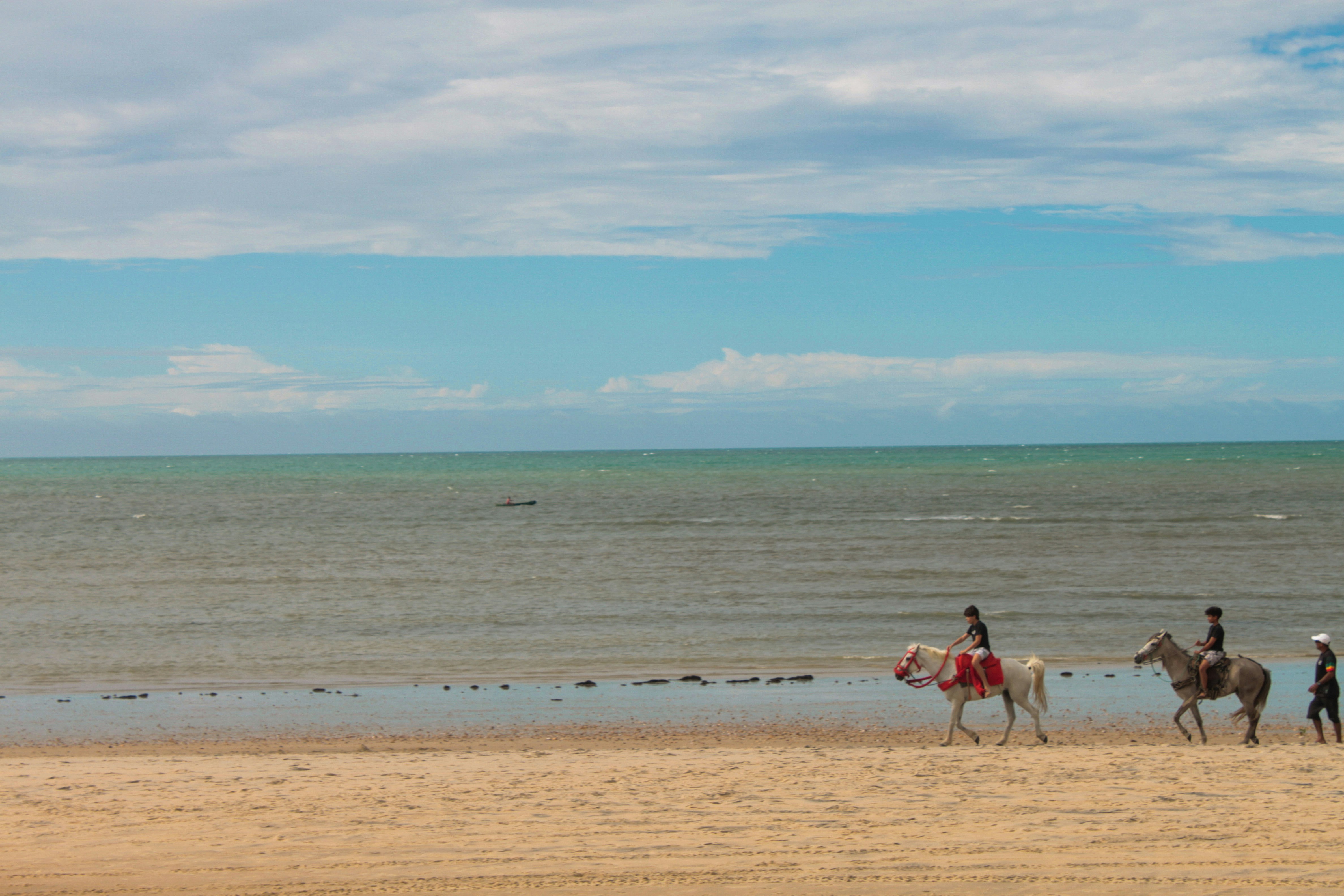 Sunlit Beach Parade: A Family Moment by the Tidal Line