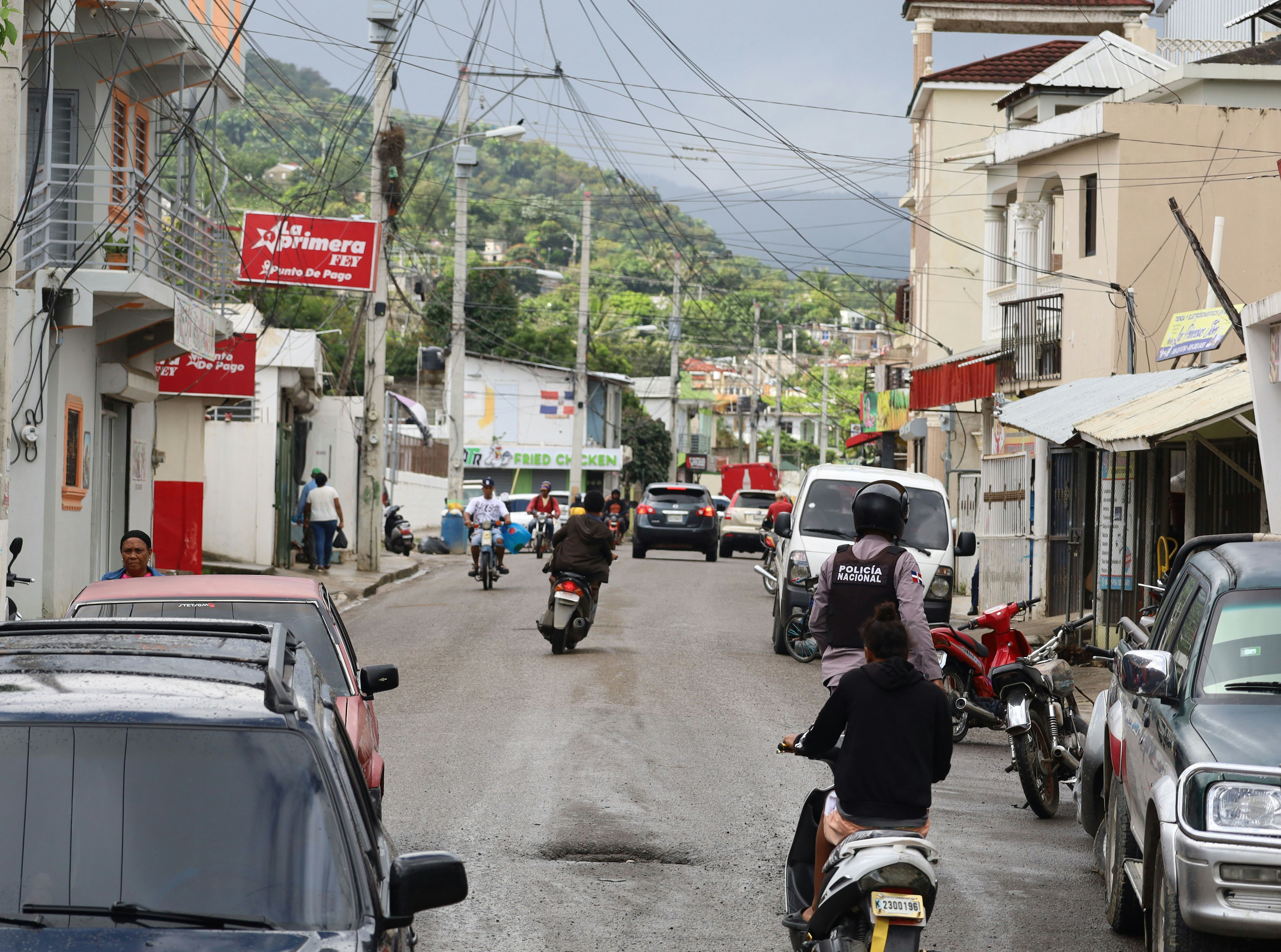 Urban Lifeline: Motorbikes and Cars Thread a Coastal Street