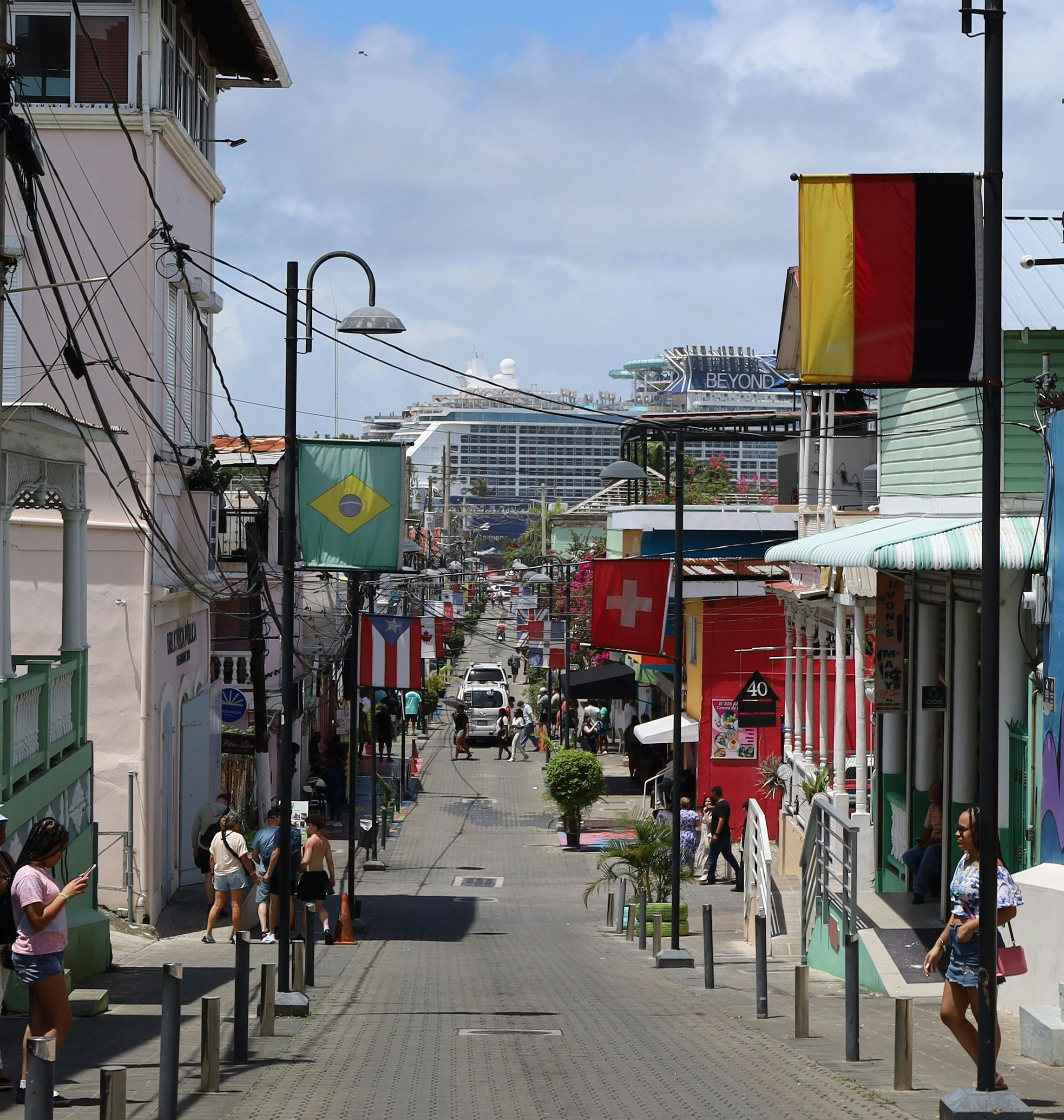 Vibrant street scene with international flags and a cruise ship.