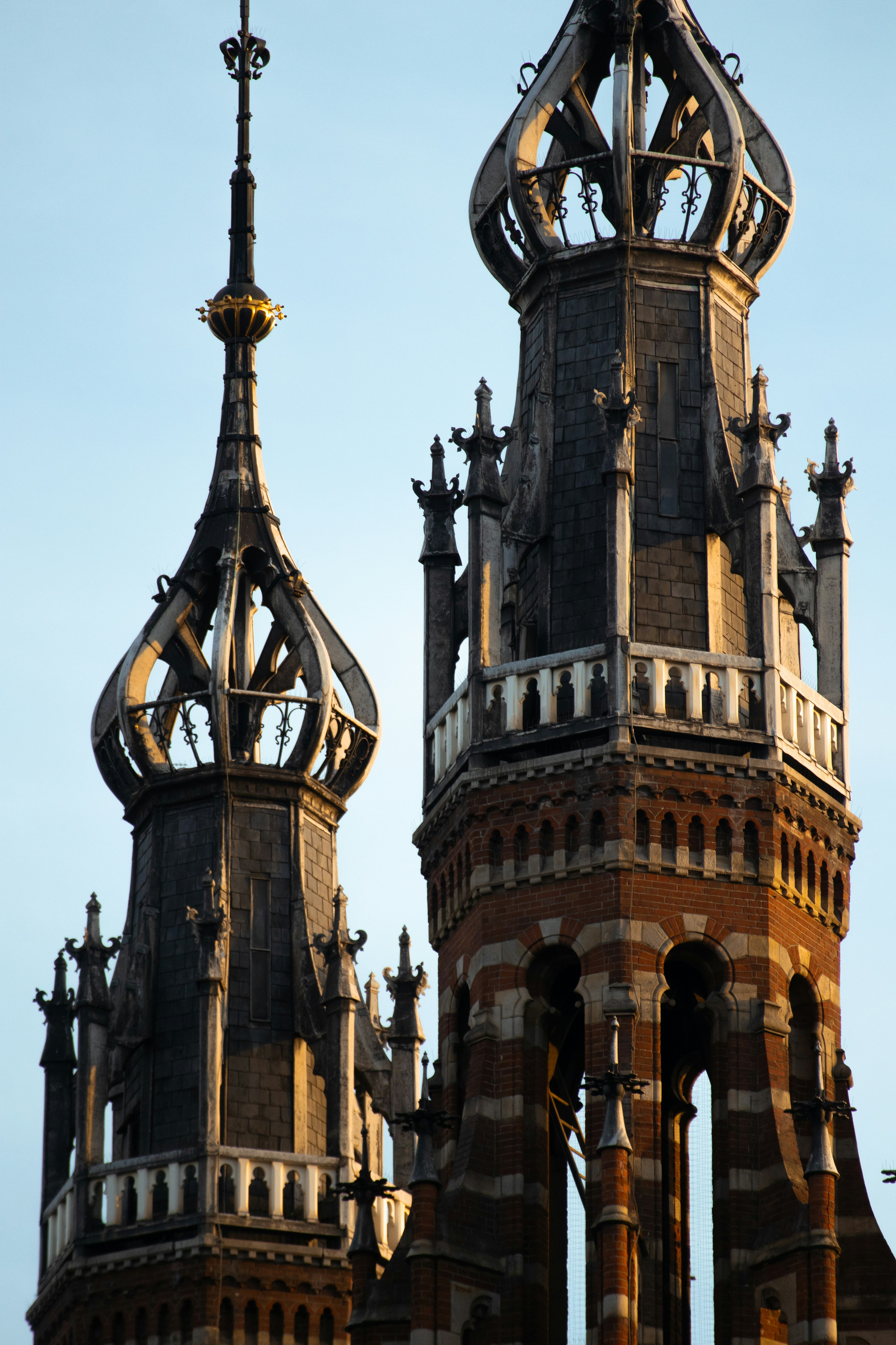 Two ornate gothic towers against a clear blue sky.