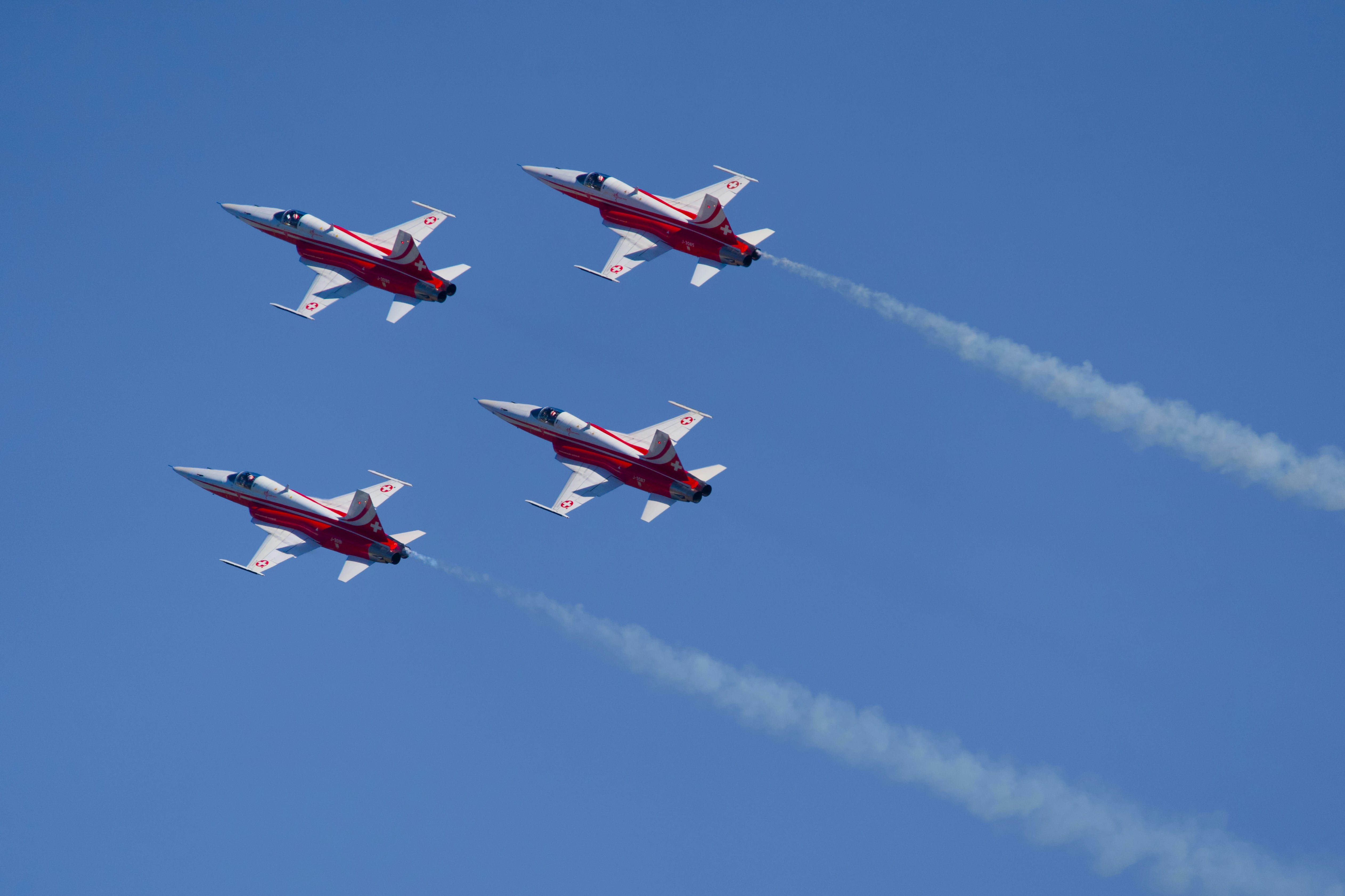 Flocked in formation: quartet of aerobatic jets carving contrails across a clear blue sky