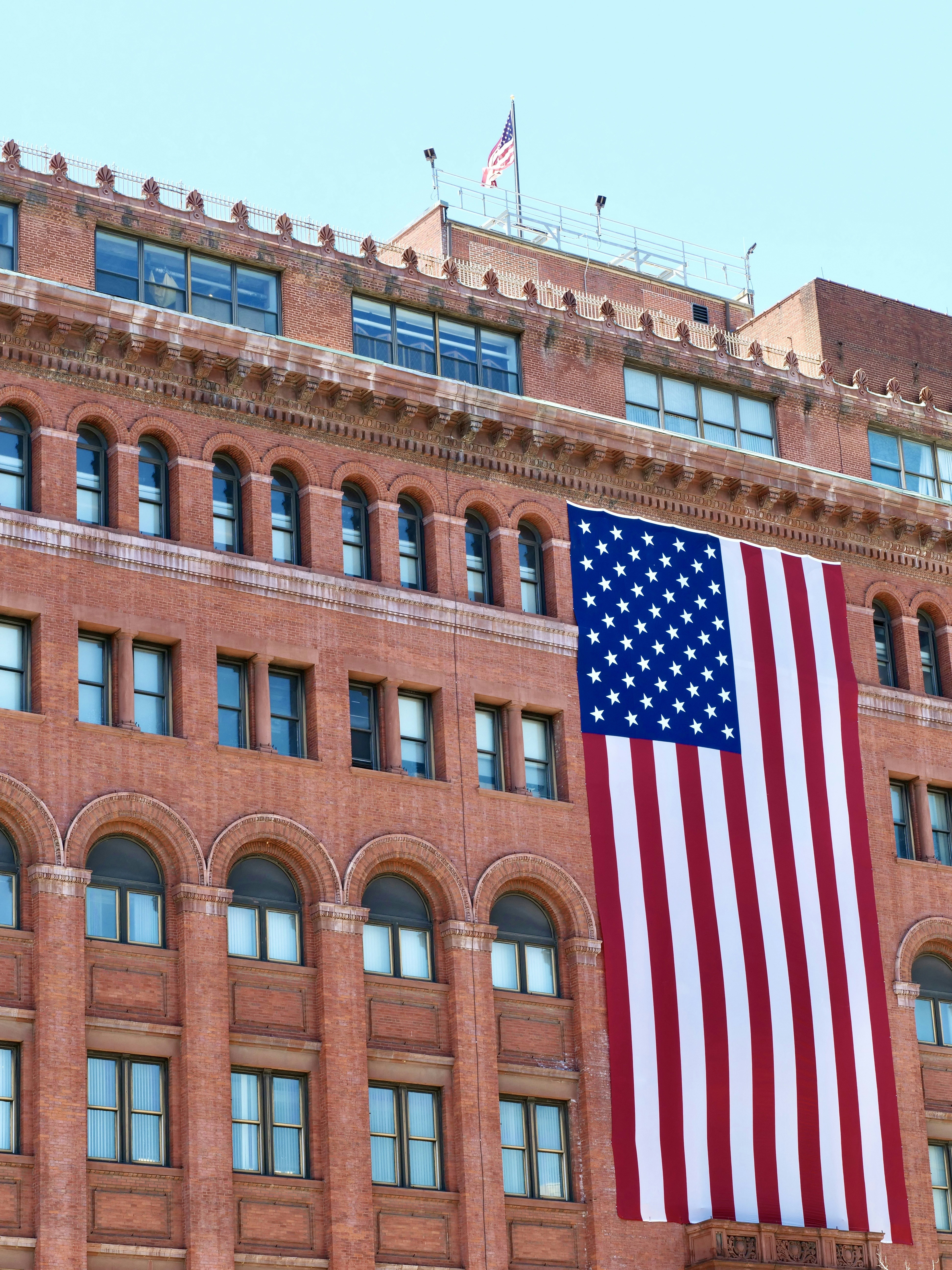 Flag Above Brick Facade: A Civic Banner Draped Over a Historic Building