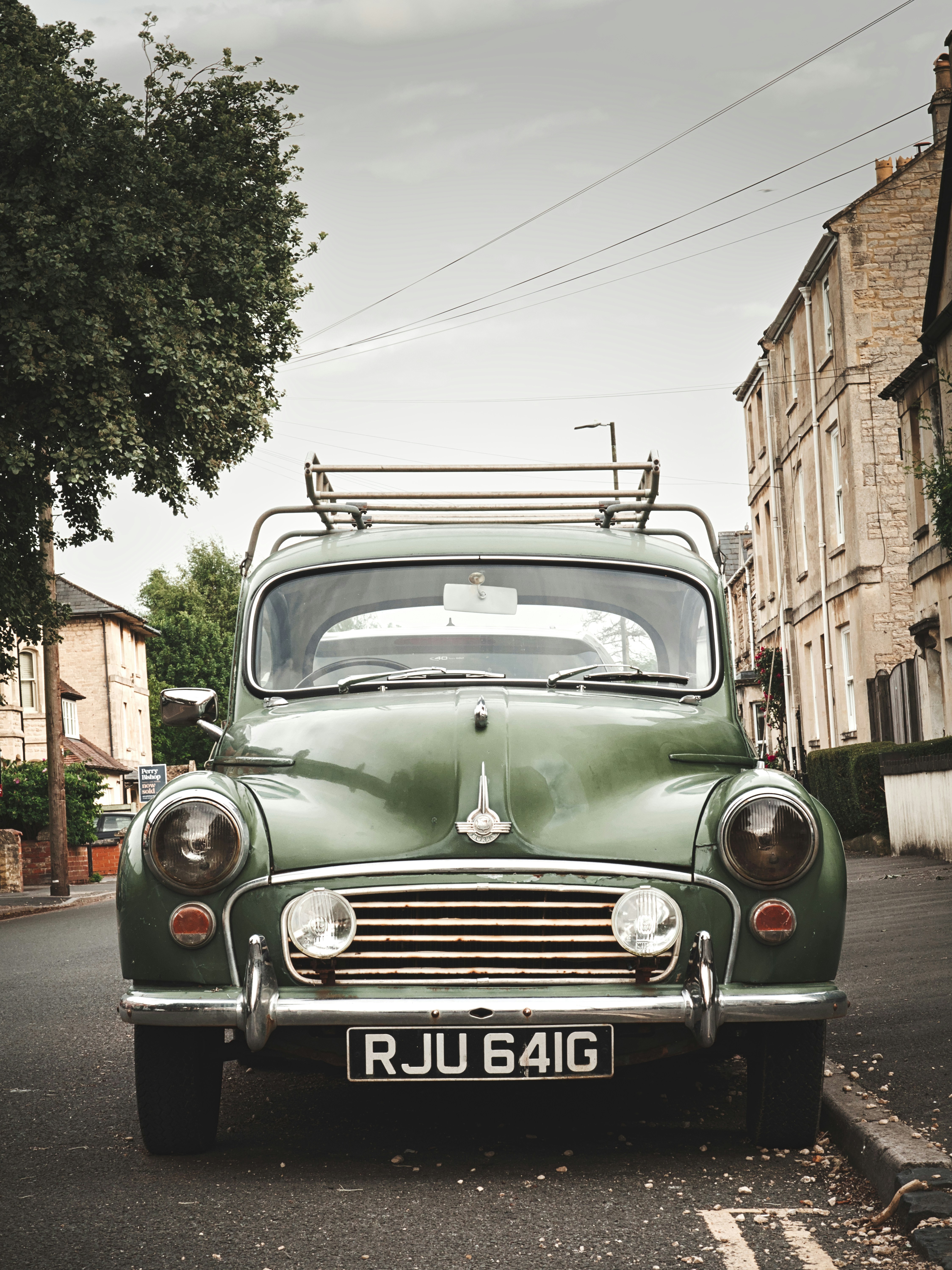 Classic Green Vintage: Front View of a Restored Rover on a Narrow Street