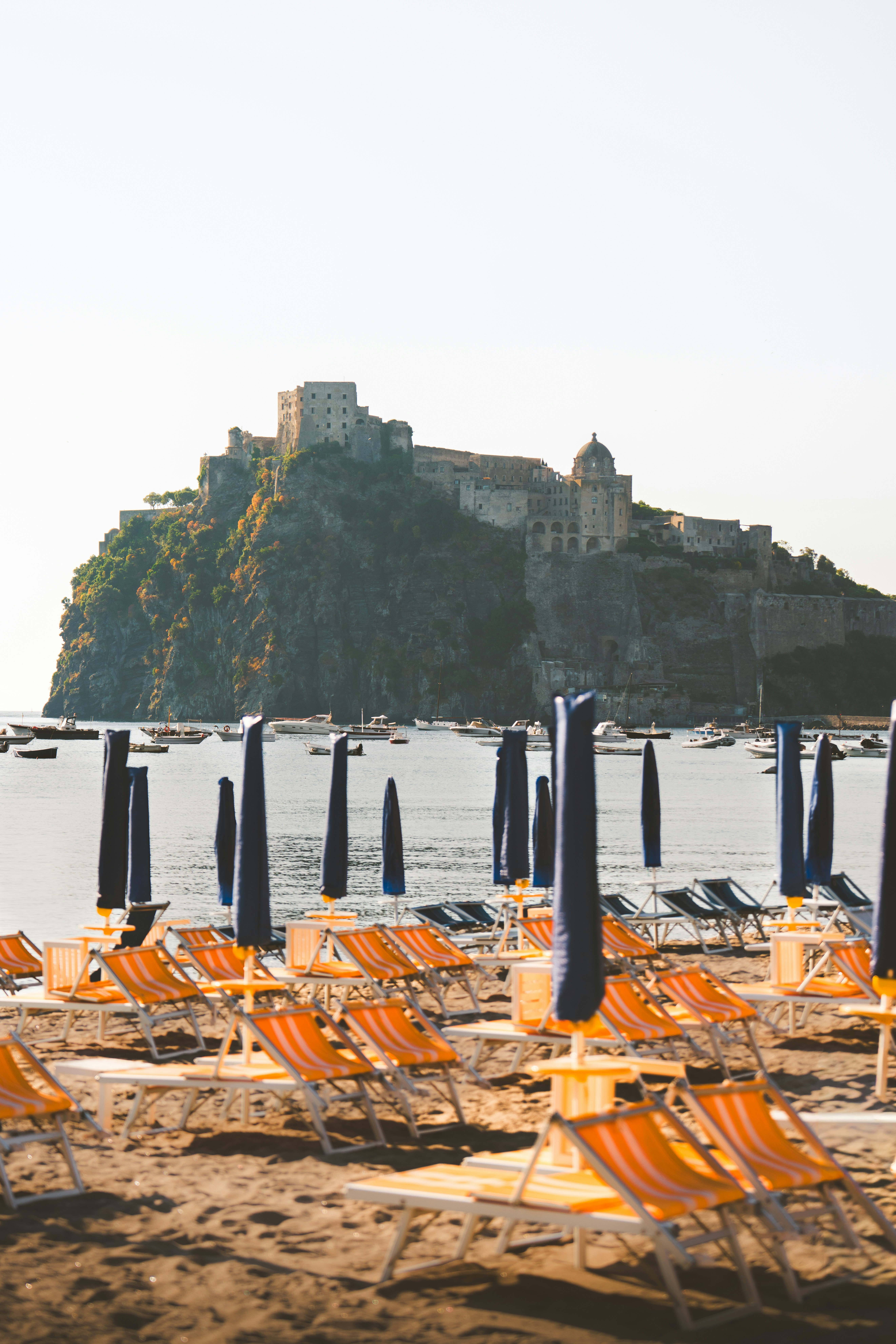 Fortress on the Isle: Beachfront Recline with Rows of Orange Lounge Chairs