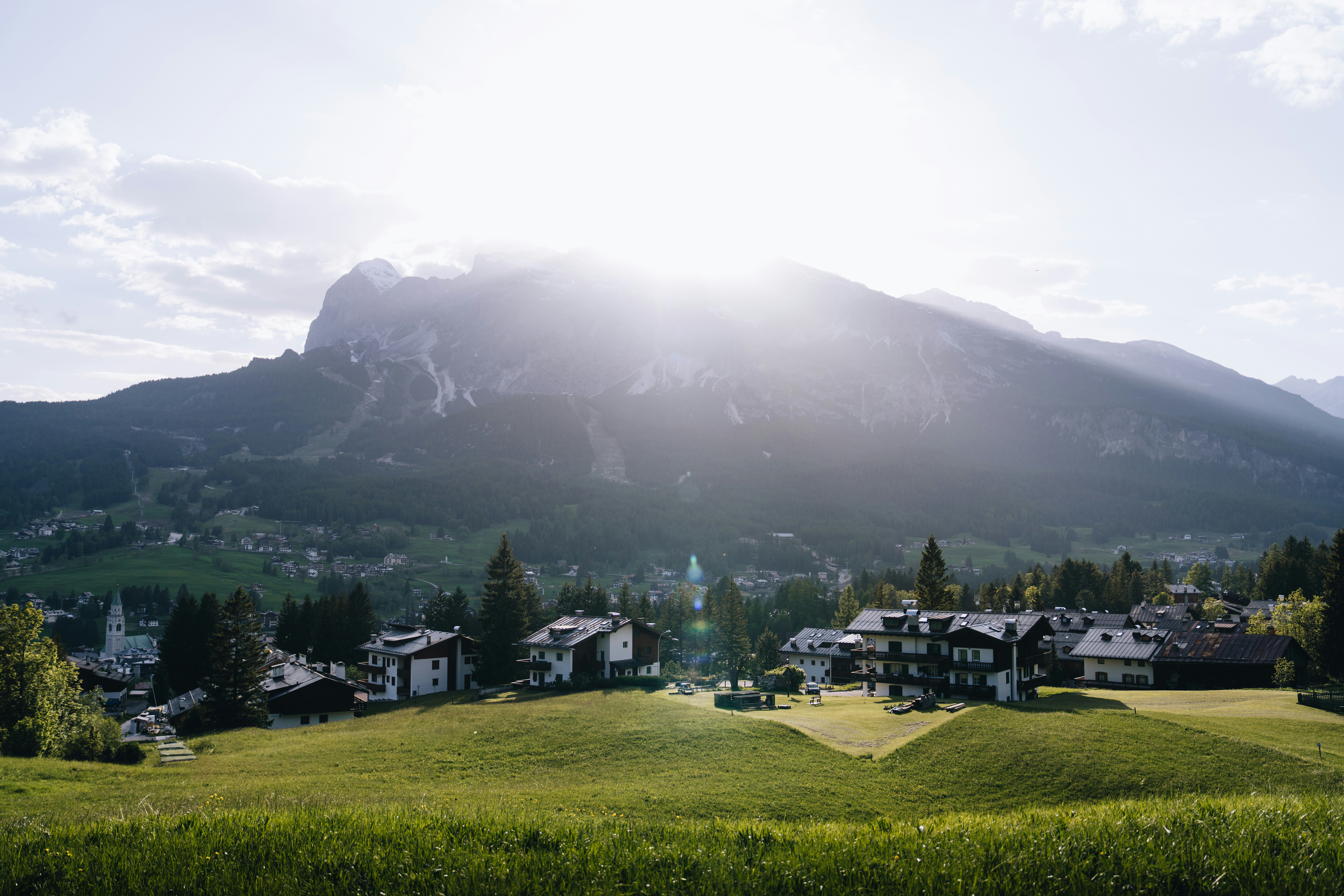 Sunlit Alpine Village at the Foot of a Caped Peak