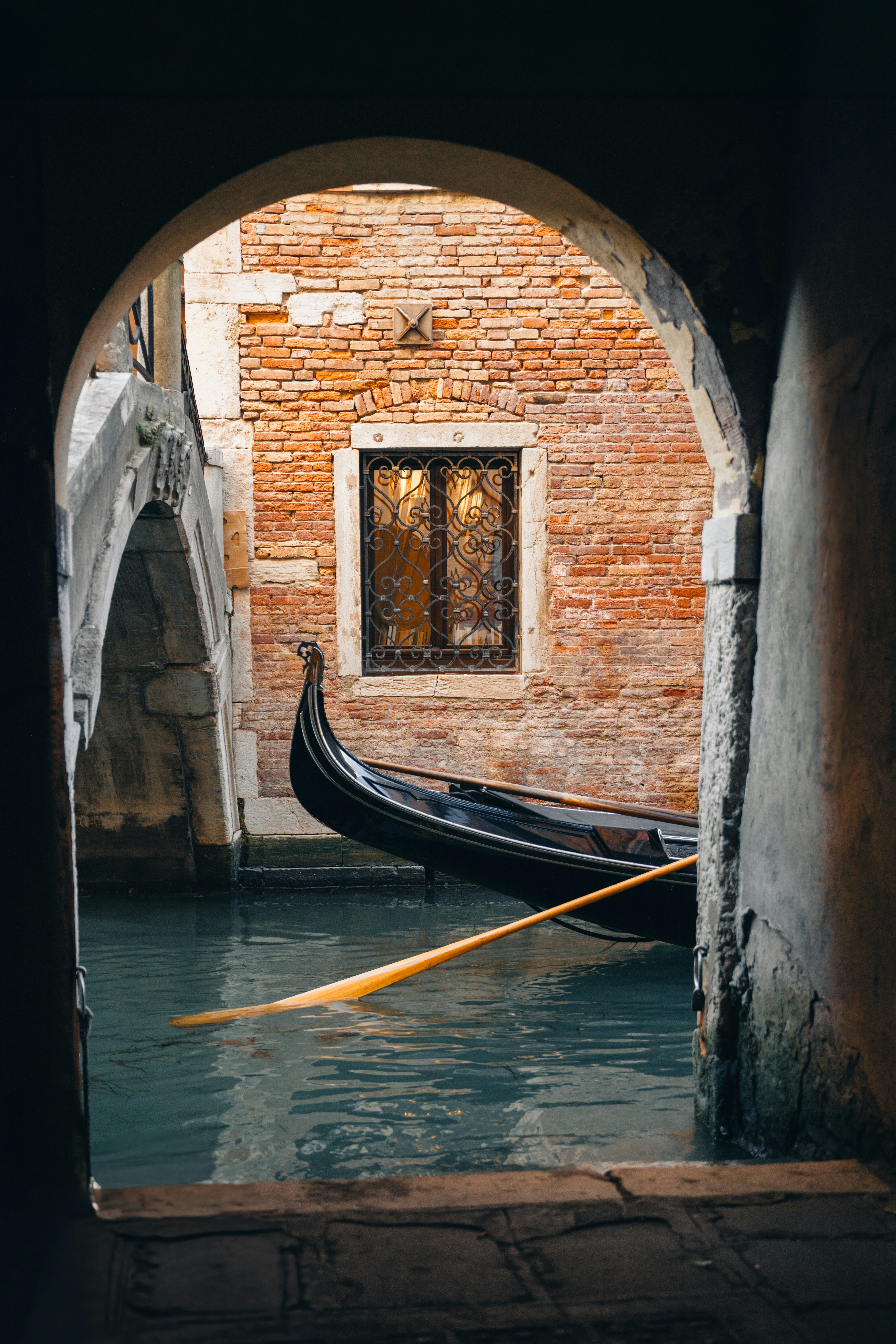 Gondola on a venice canal viewed through an archway.