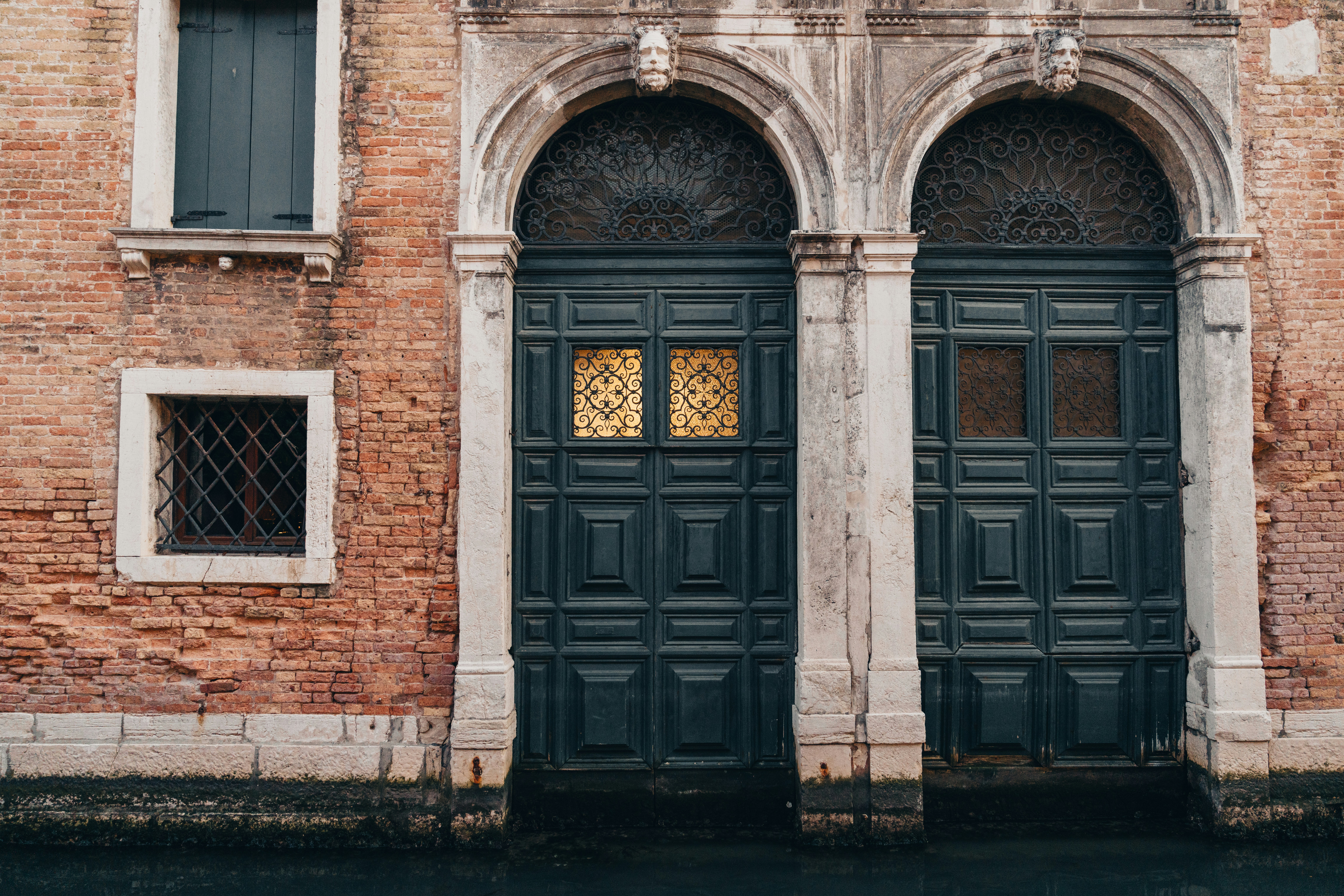 Weathered Doors Between Brick Arches