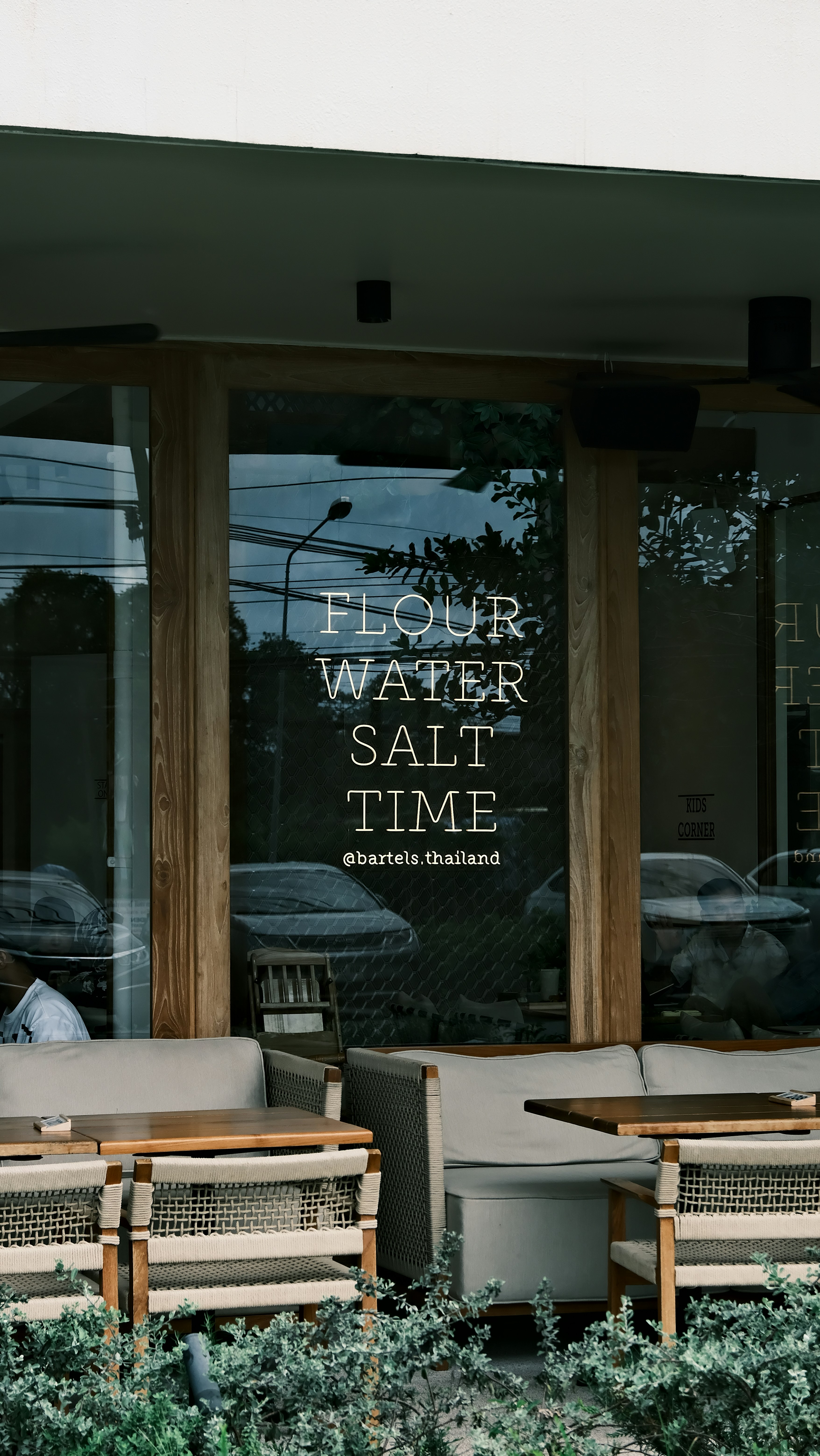 Quiet Café Facade with Textured Seating and Glass Window