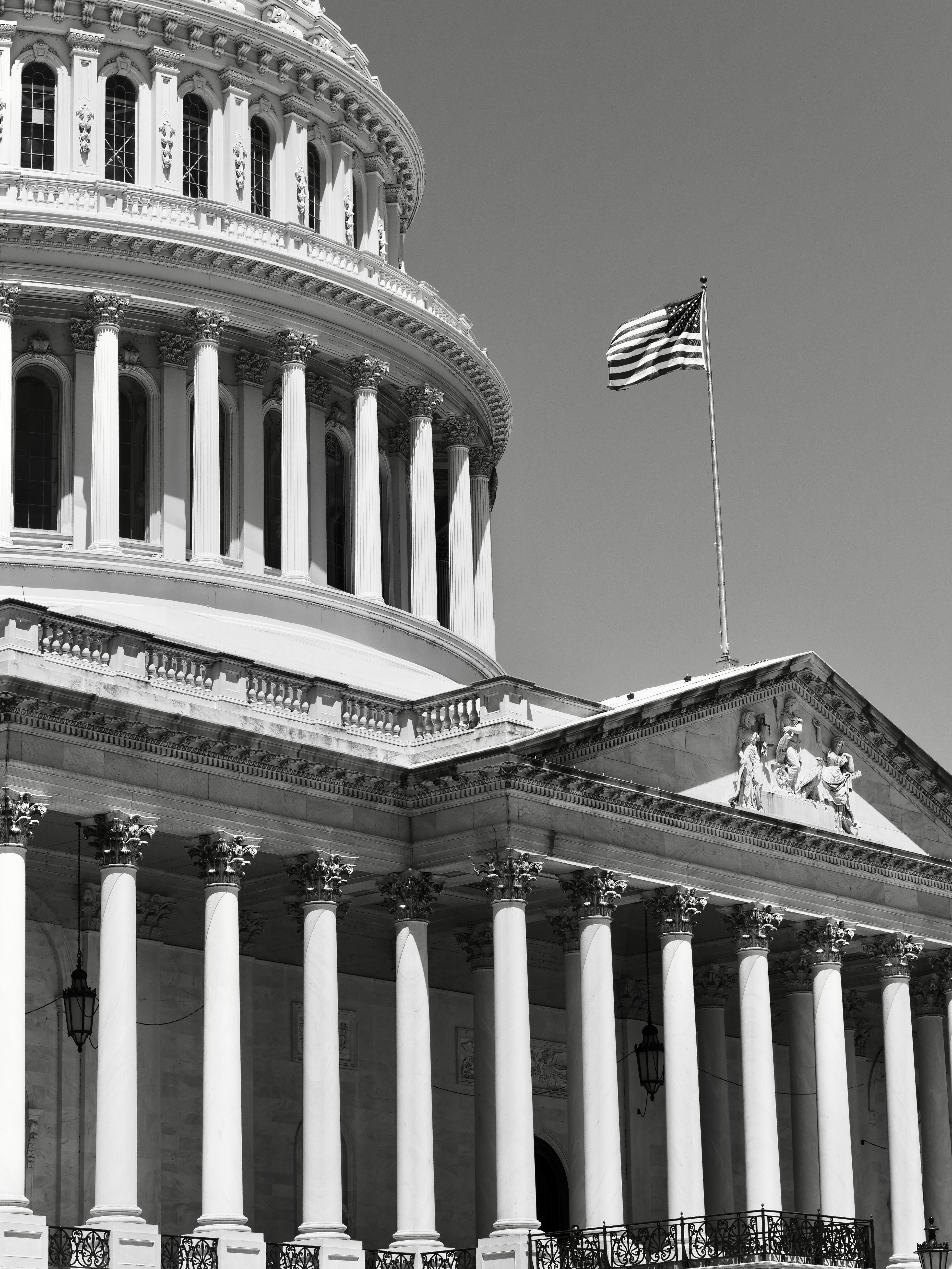 Capitol Facade in Focus: Columns, Entablature, and Flag