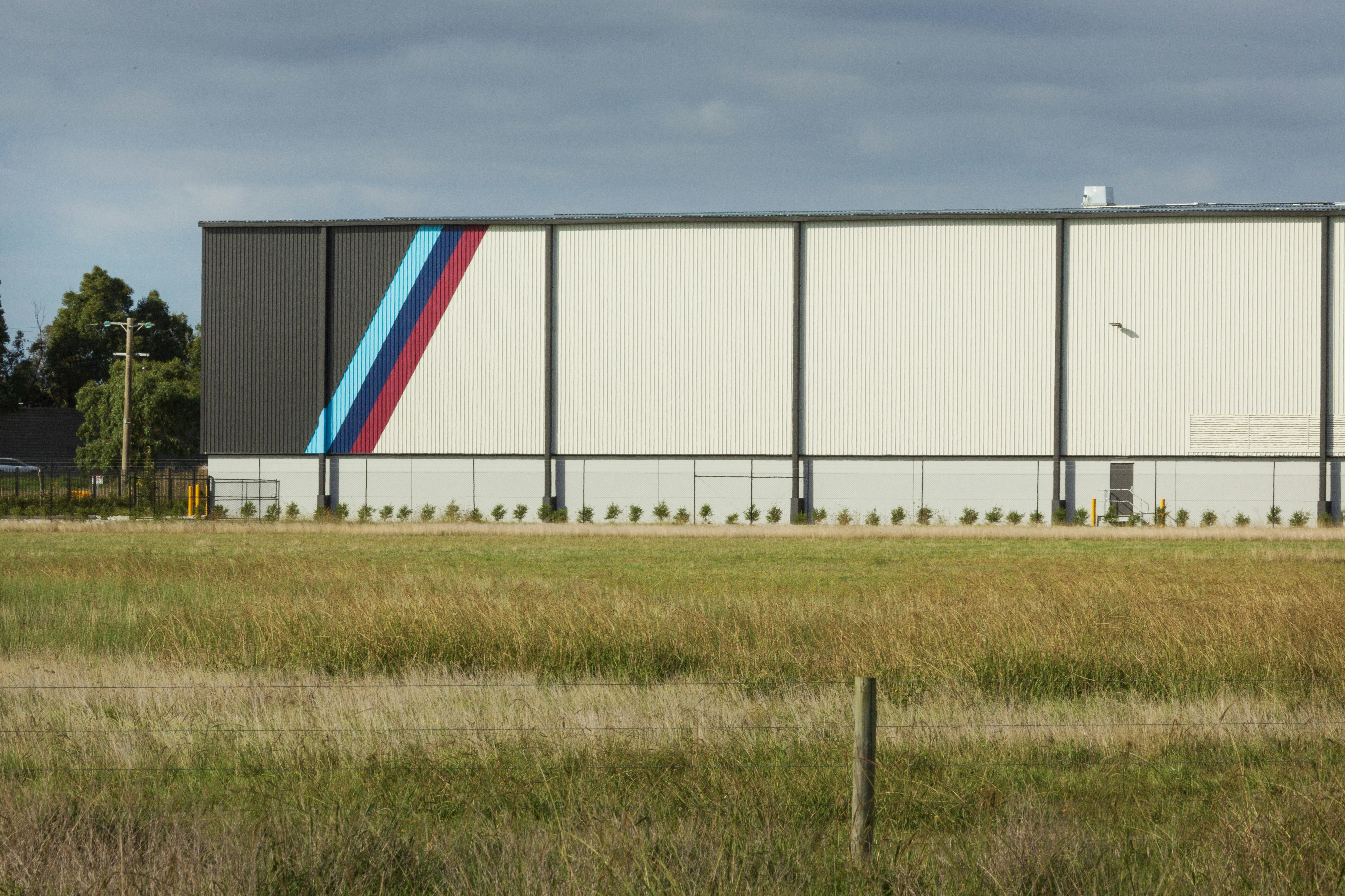 Industrial Wing: A Streamlined Facade Ascendant over Golden Field