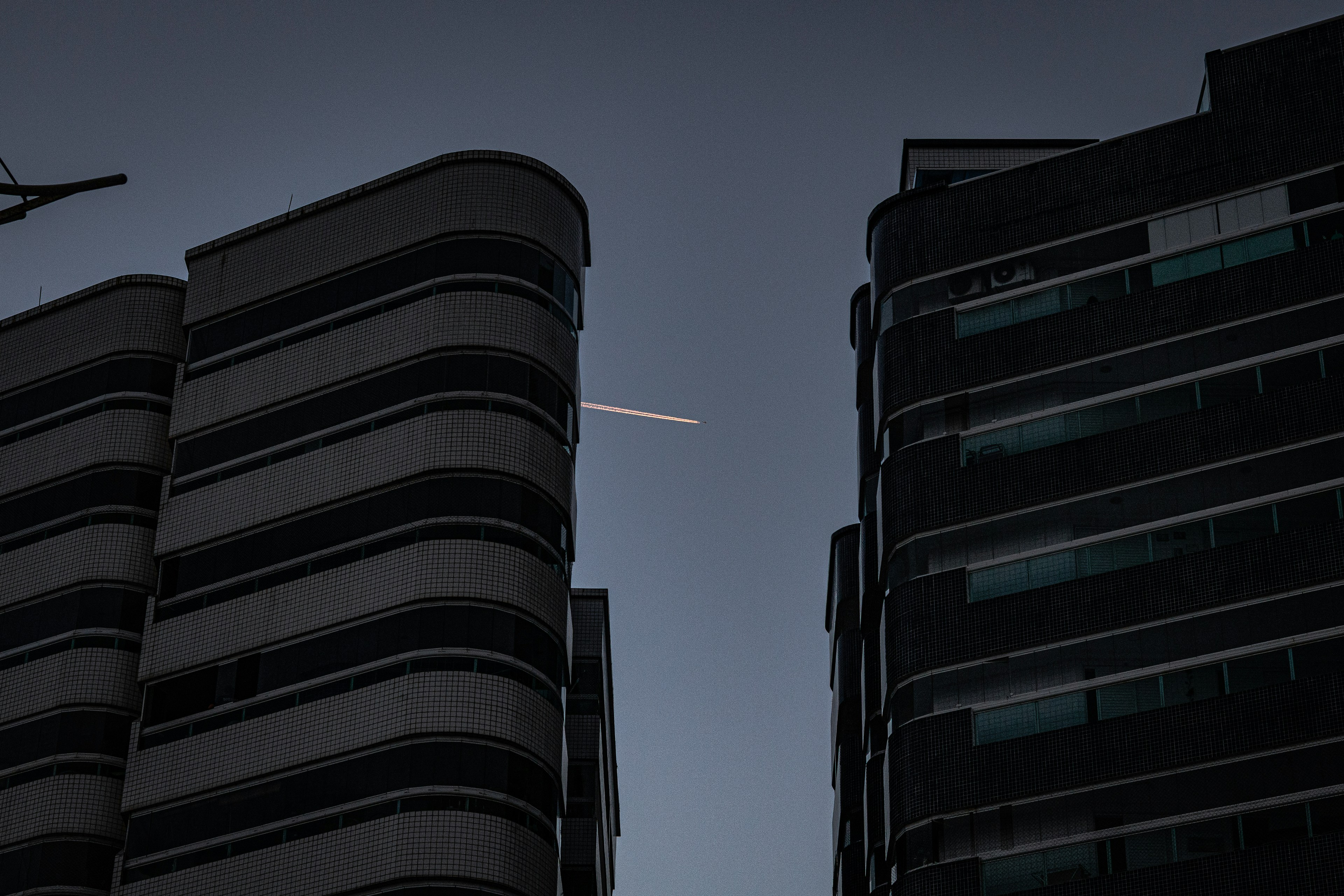 Jet of light between urban towers at twilight