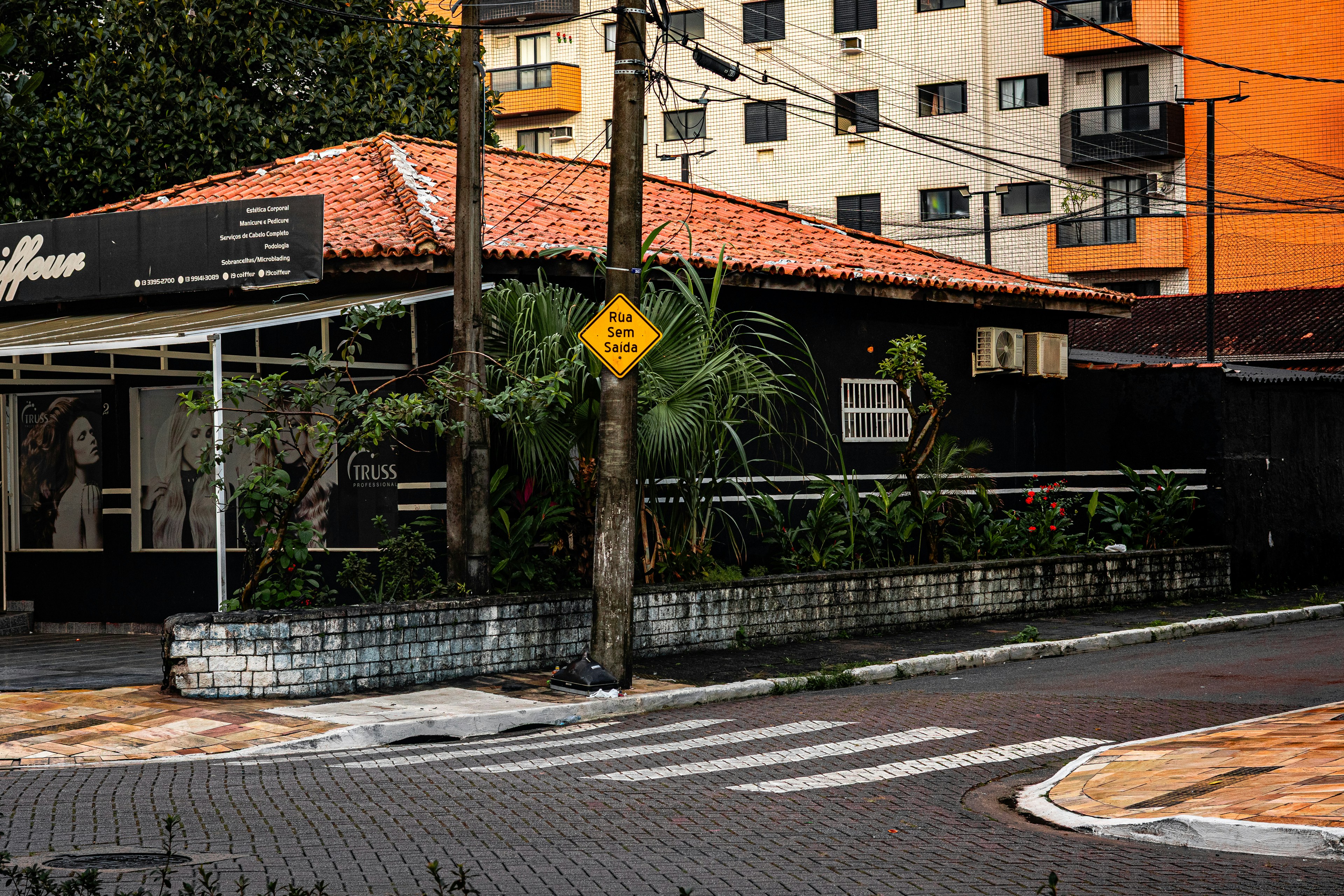 A street corner with a salon and apartment buildings, a 'dead end' sign visible.
