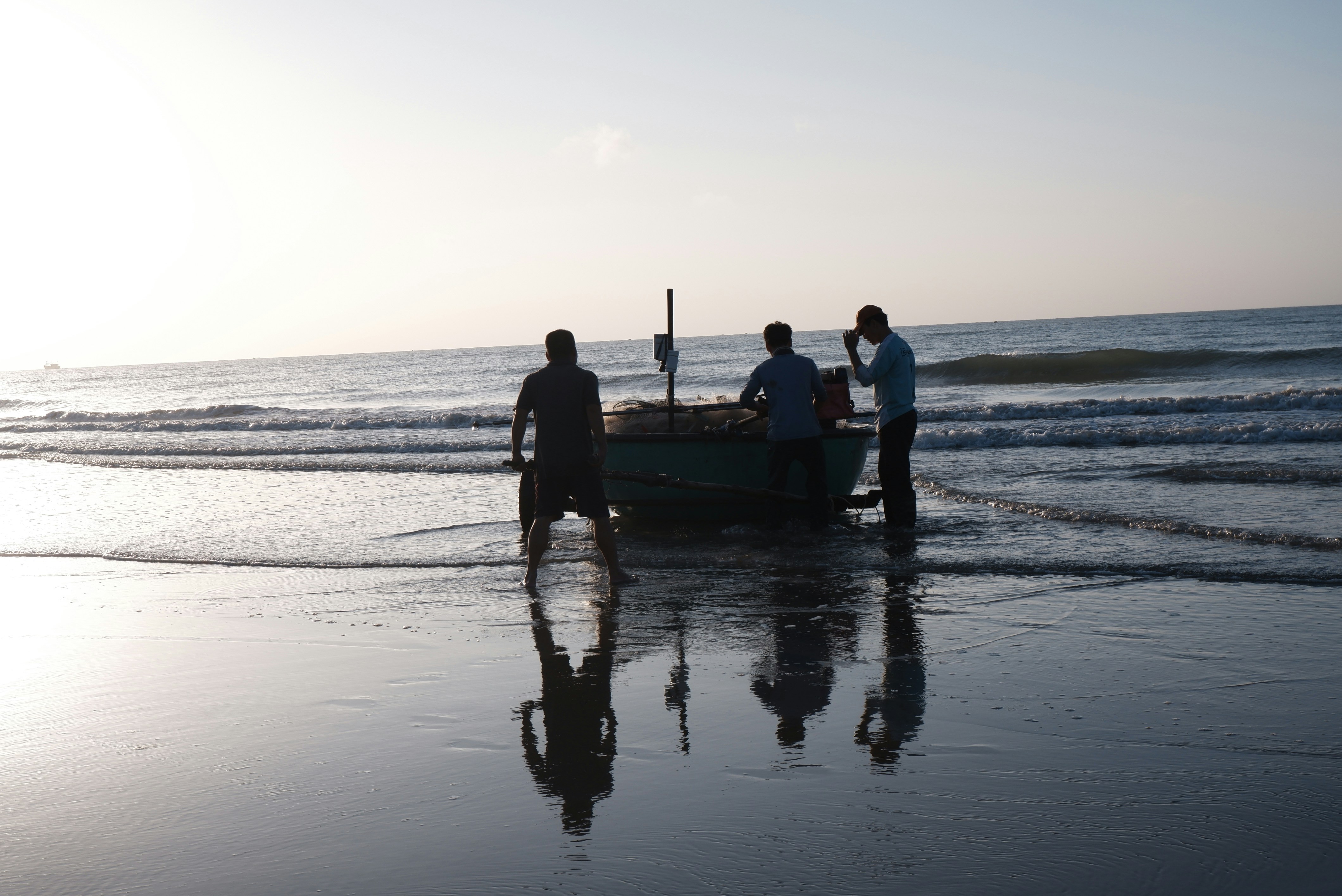 Shadowed Crew by the Shore: A Boat Becomes the Focal Moment