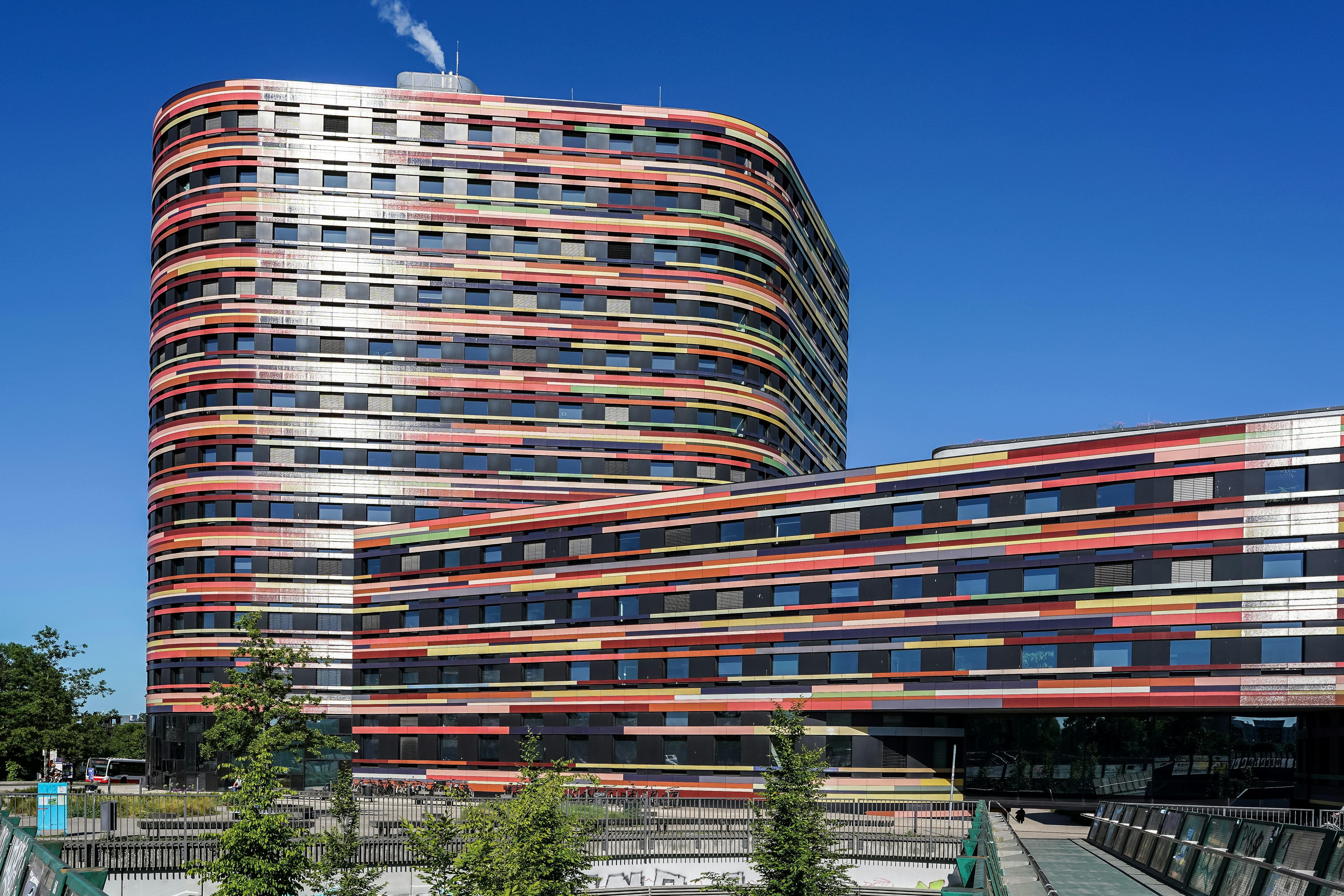 Ribboned Facade: A Multicolor Modernist Tower Under a Clear Sky