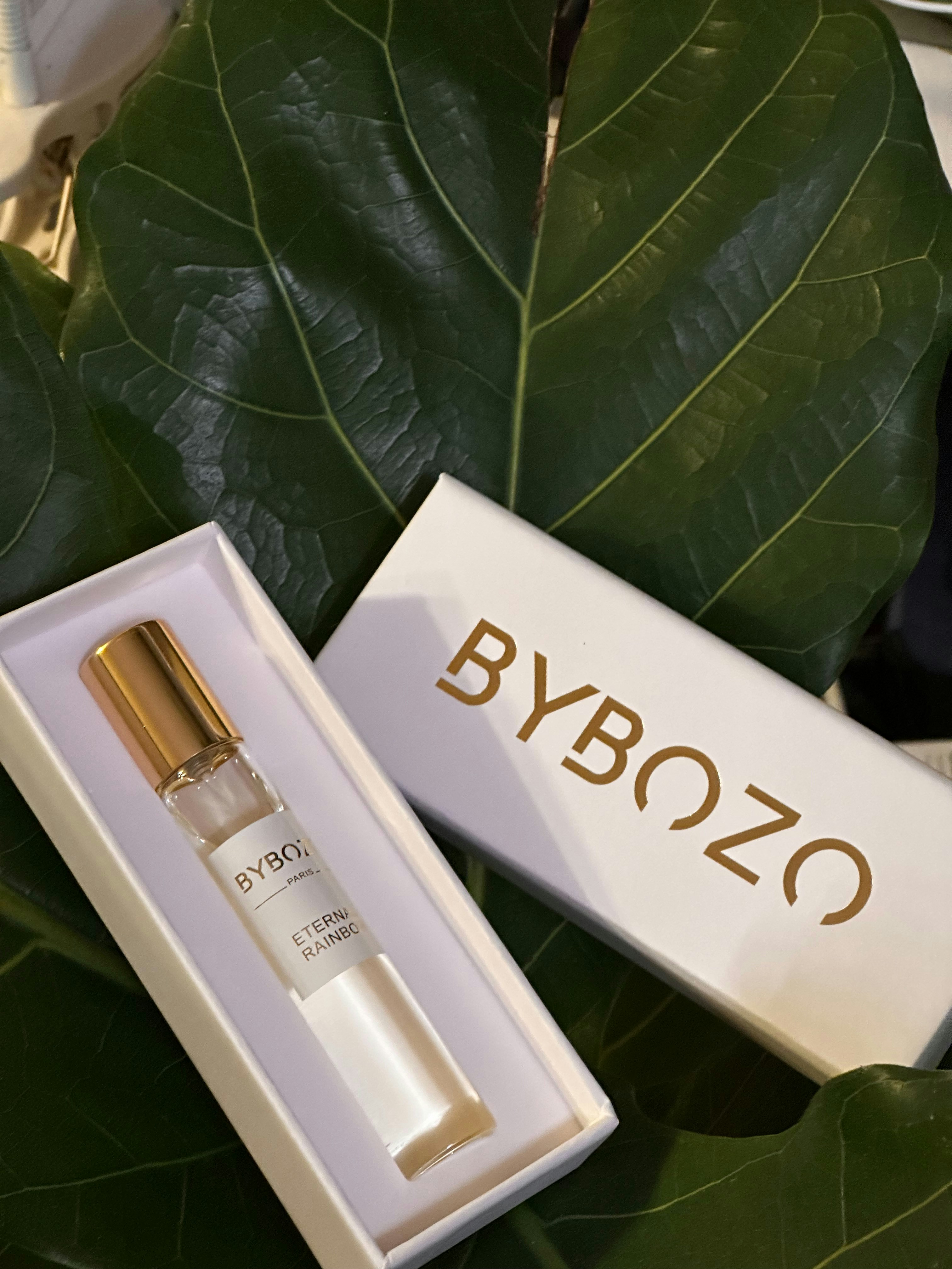 A bybozo perfume bottle in its box on green leaves.